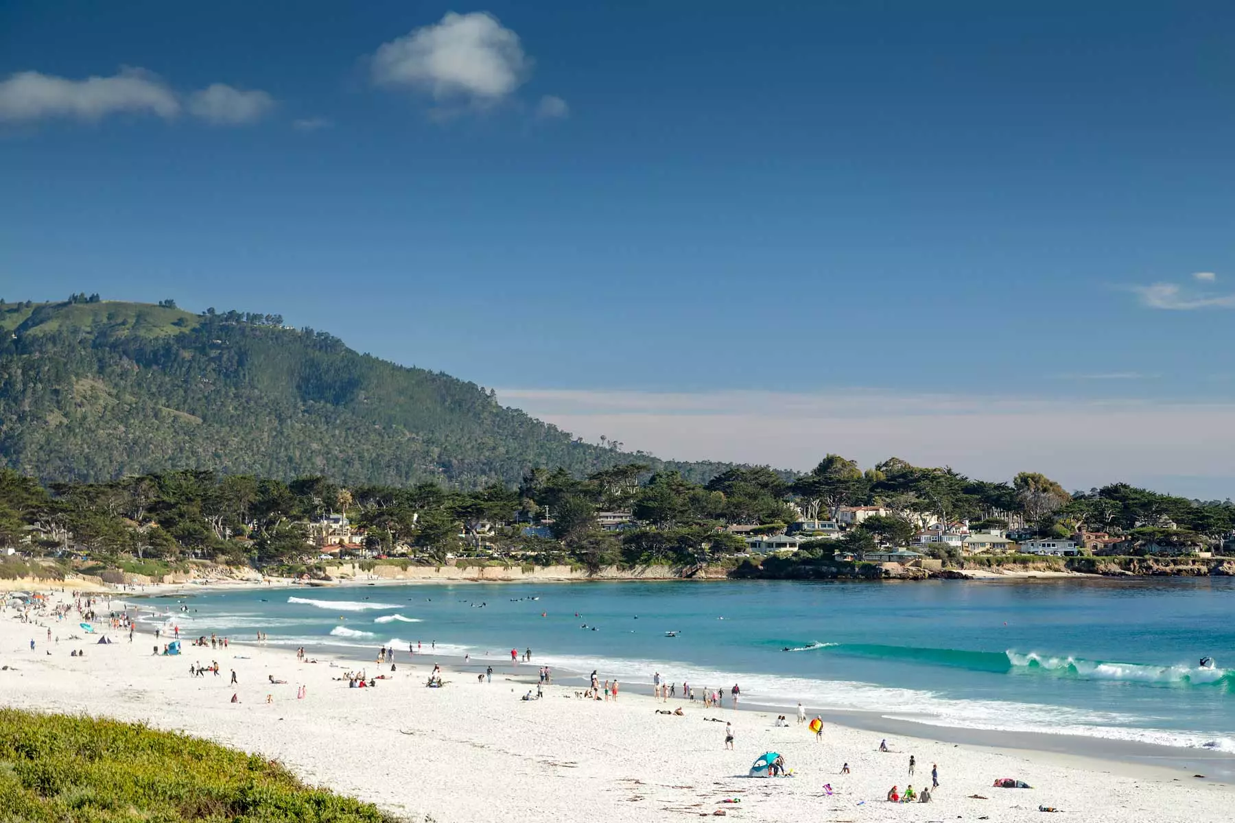 Emberek élvezik a Carmel strand aranyhomokos homokját egy meleg tavaszi napon, Carmel, Kalifornia.