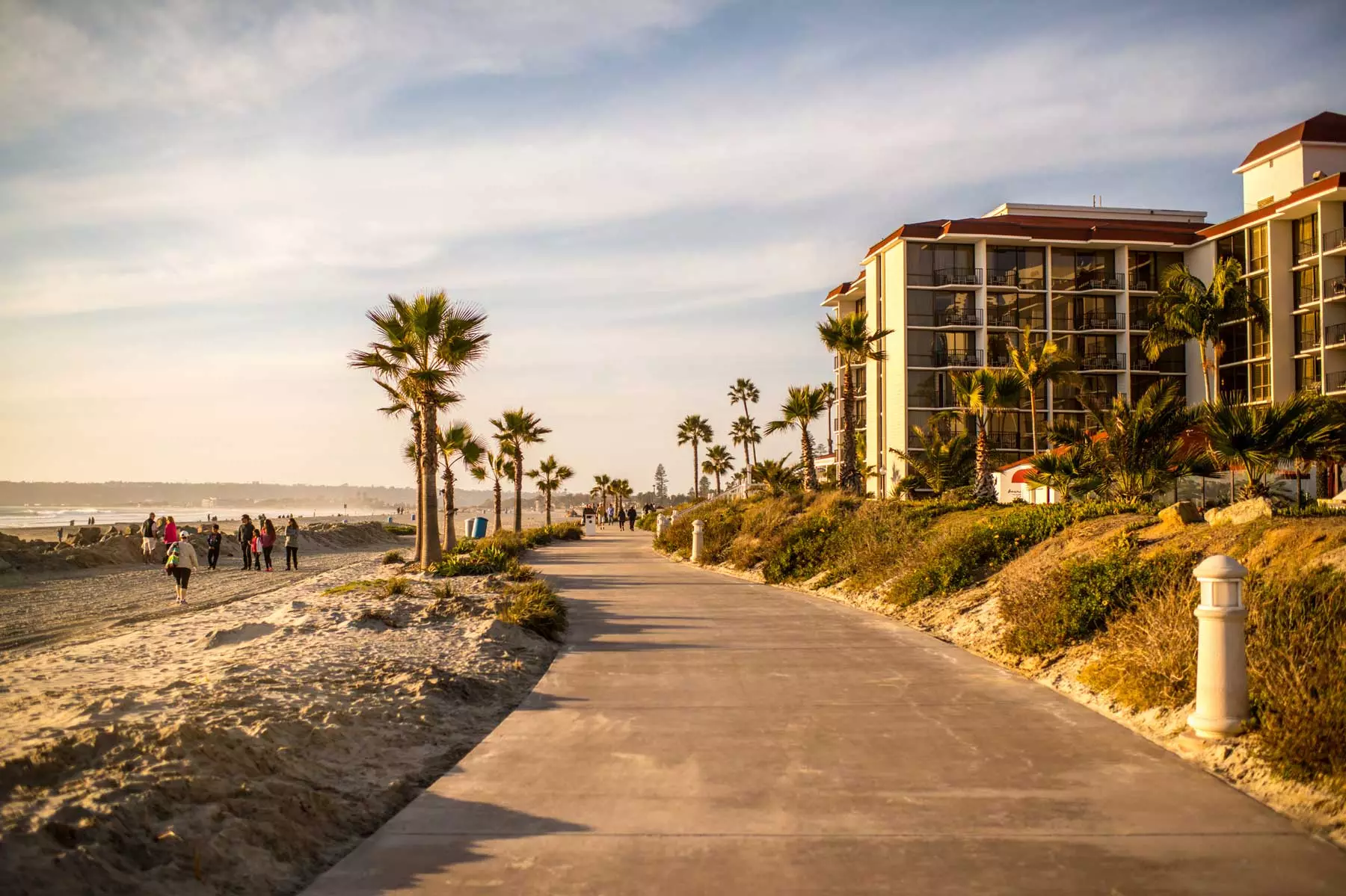 Orang-orang berjalan di sepanjang pantai Coronado di San Diego