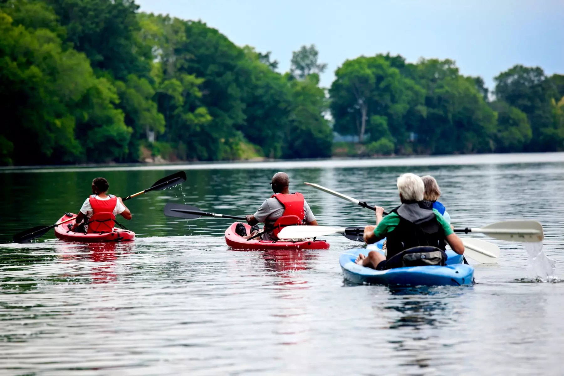 Ẹgbẹ ti owan Kayaking lori omi.