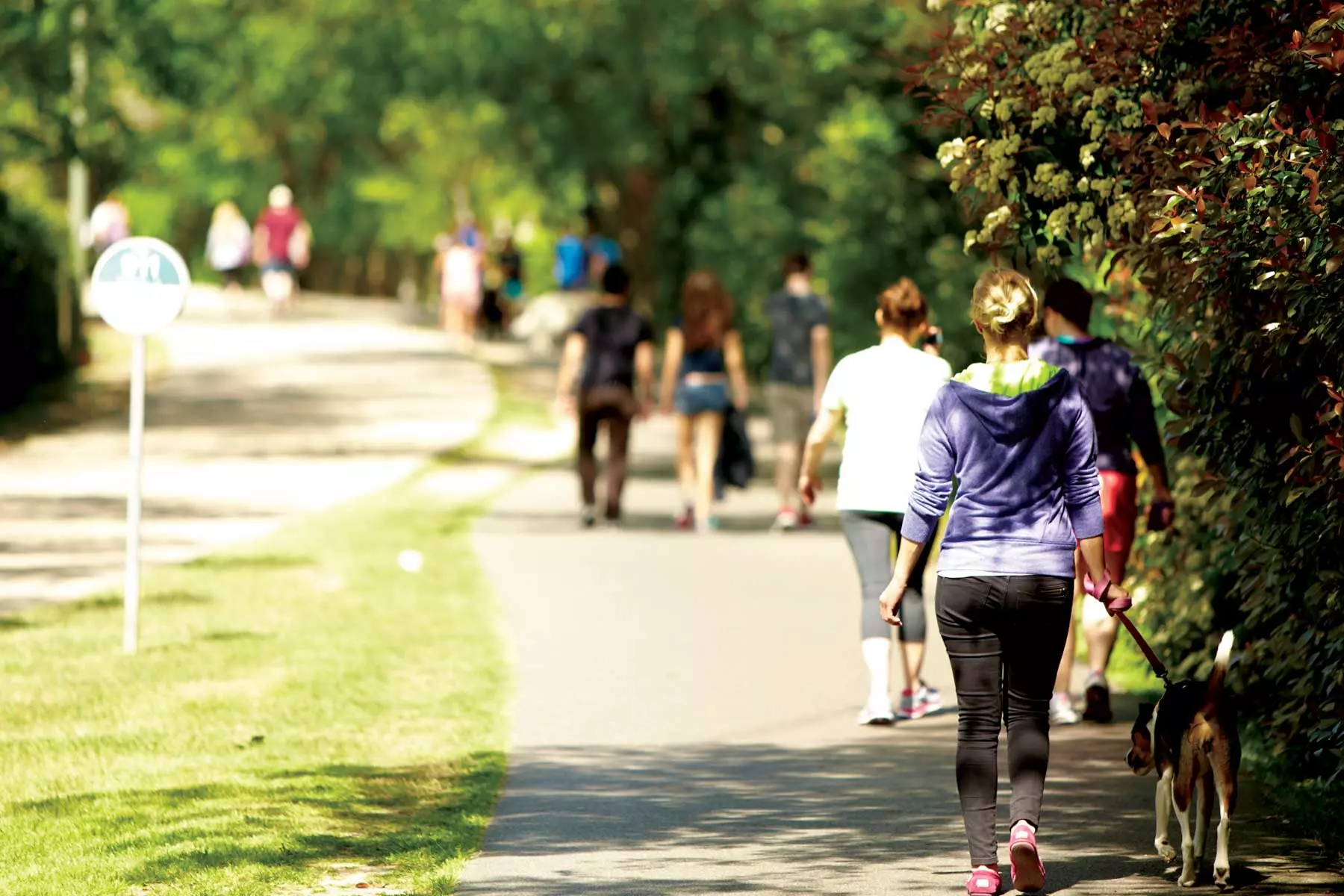 Folk, der går langs Katy Trail på en solskinsdag i Dallas, Texas