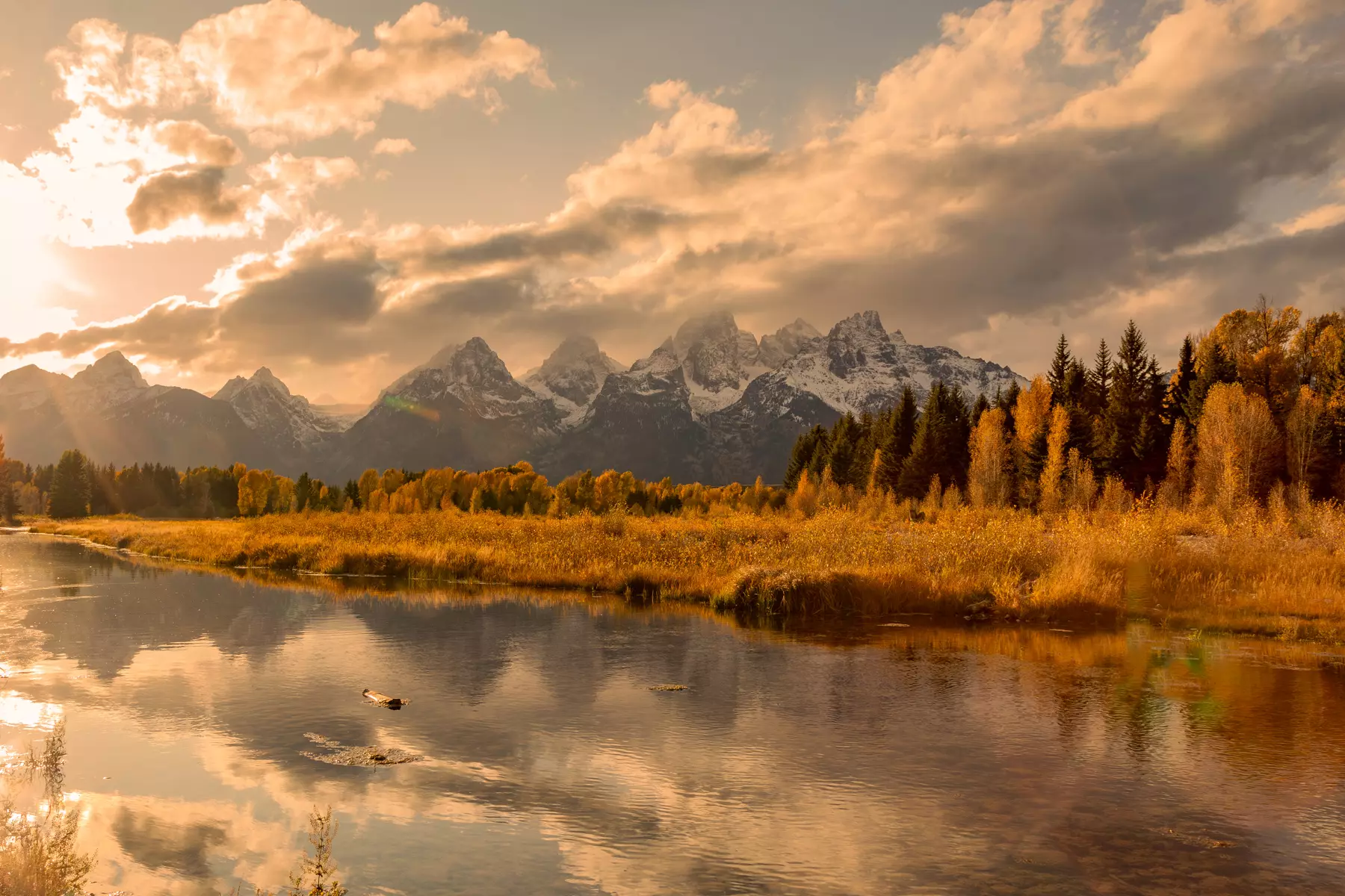 Luí na gréine ar na Grand Tetons i Wyoming