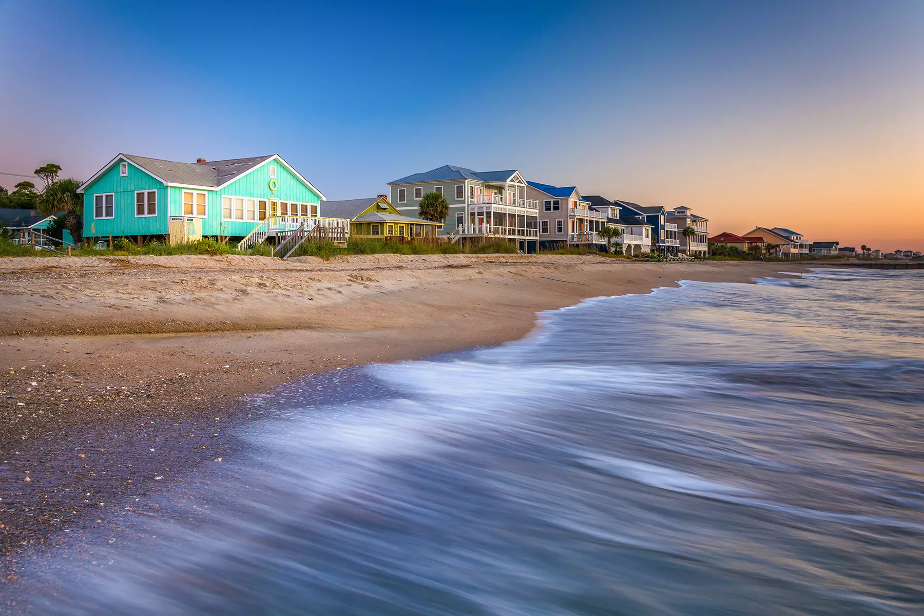 Hullámok az Atlanti-óceánon és tengerparti házak napkeltekor, Edisto Beach, Dél-Karolina