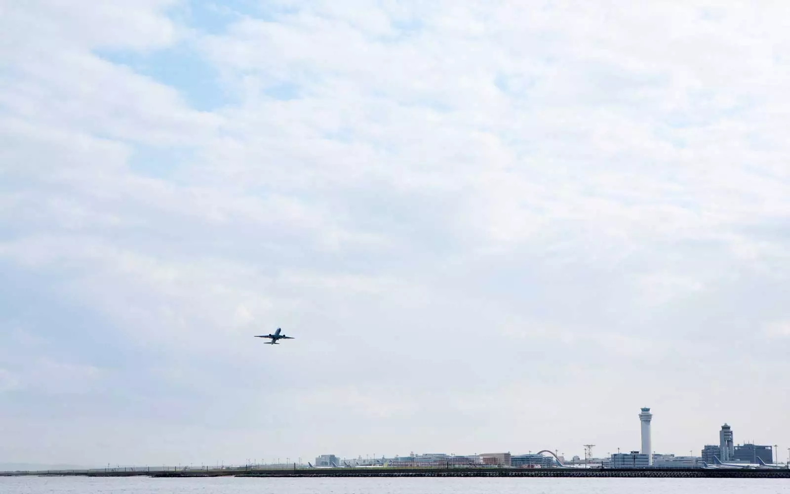 一架飛機從海邊的機場起飛。
