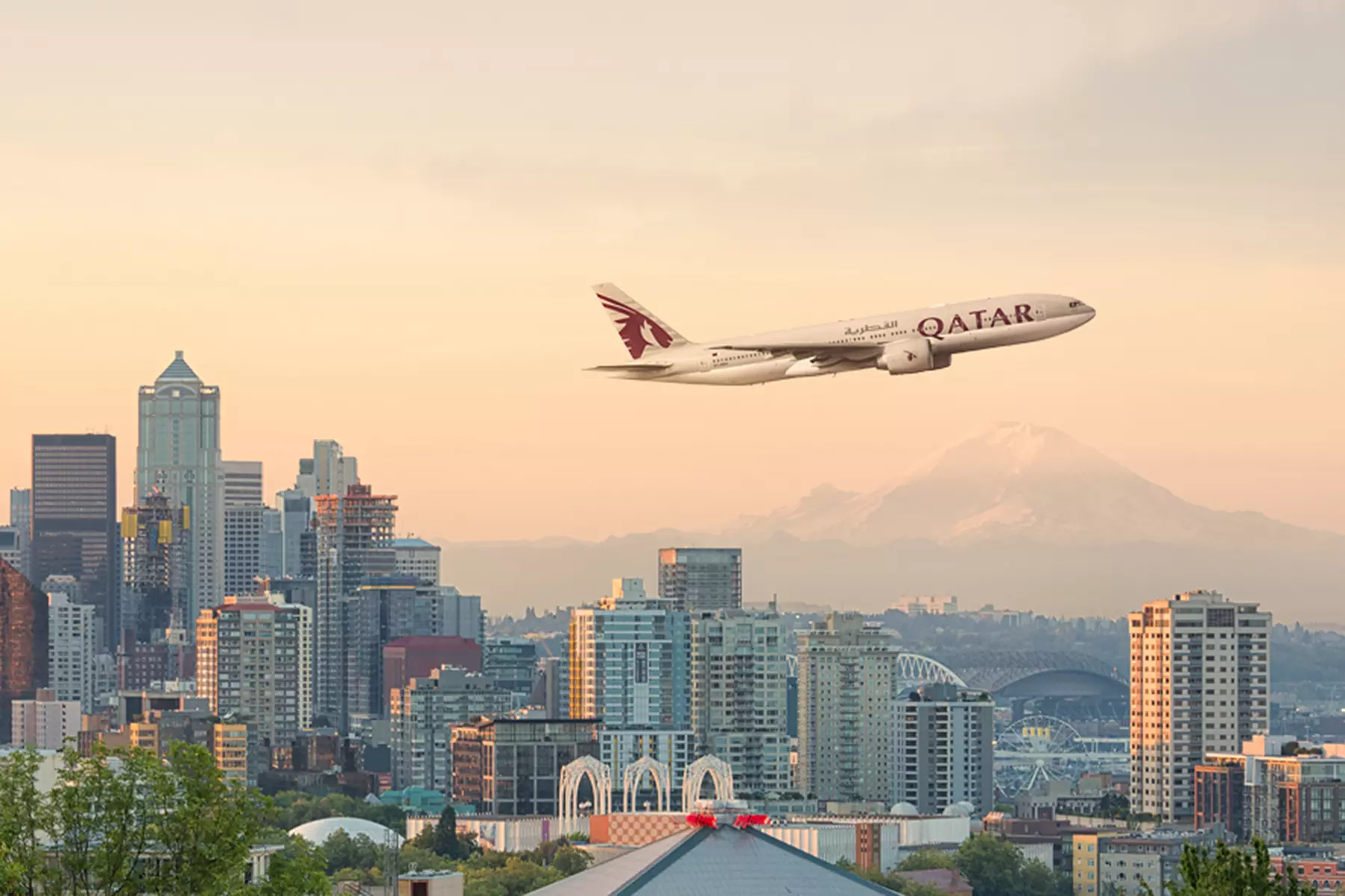 Qatar Airways-vliegtuig dat over een stad vliegt