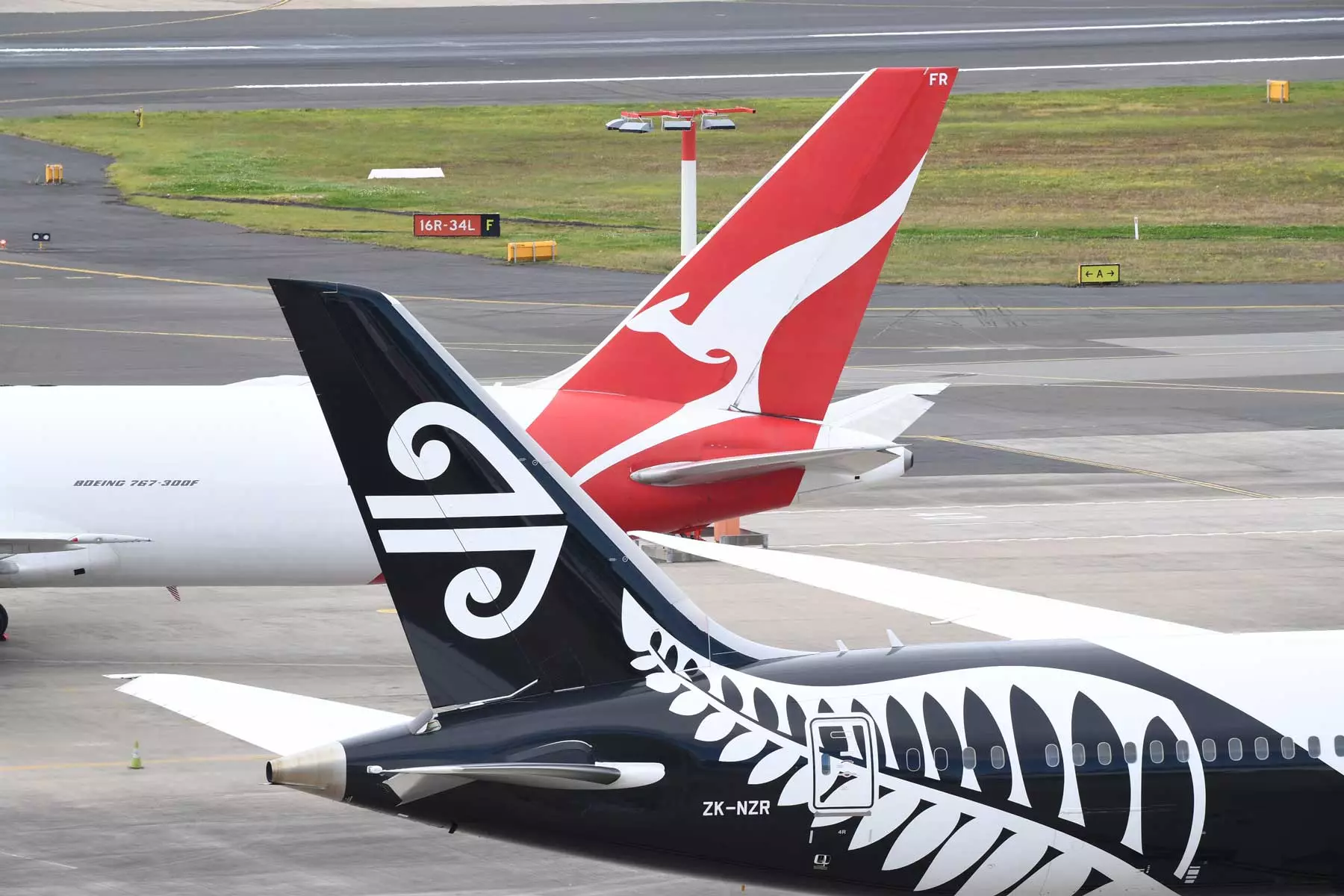 Air New Zealand samolyoti va Qantas samolyoti 2021-yil 26-iyul kuni Avstraliyaning Sidney shahridagi Kingsford Smit xalqaro aeroportida uchish perronida.