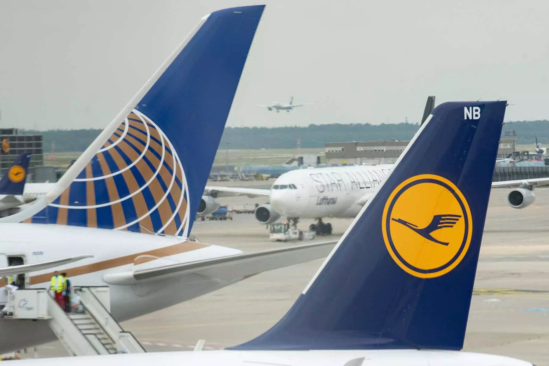 Sebuah pesawat penumpang Lufthansa (r) dan United Airlines berdiri di atas apron lapangan terbang.