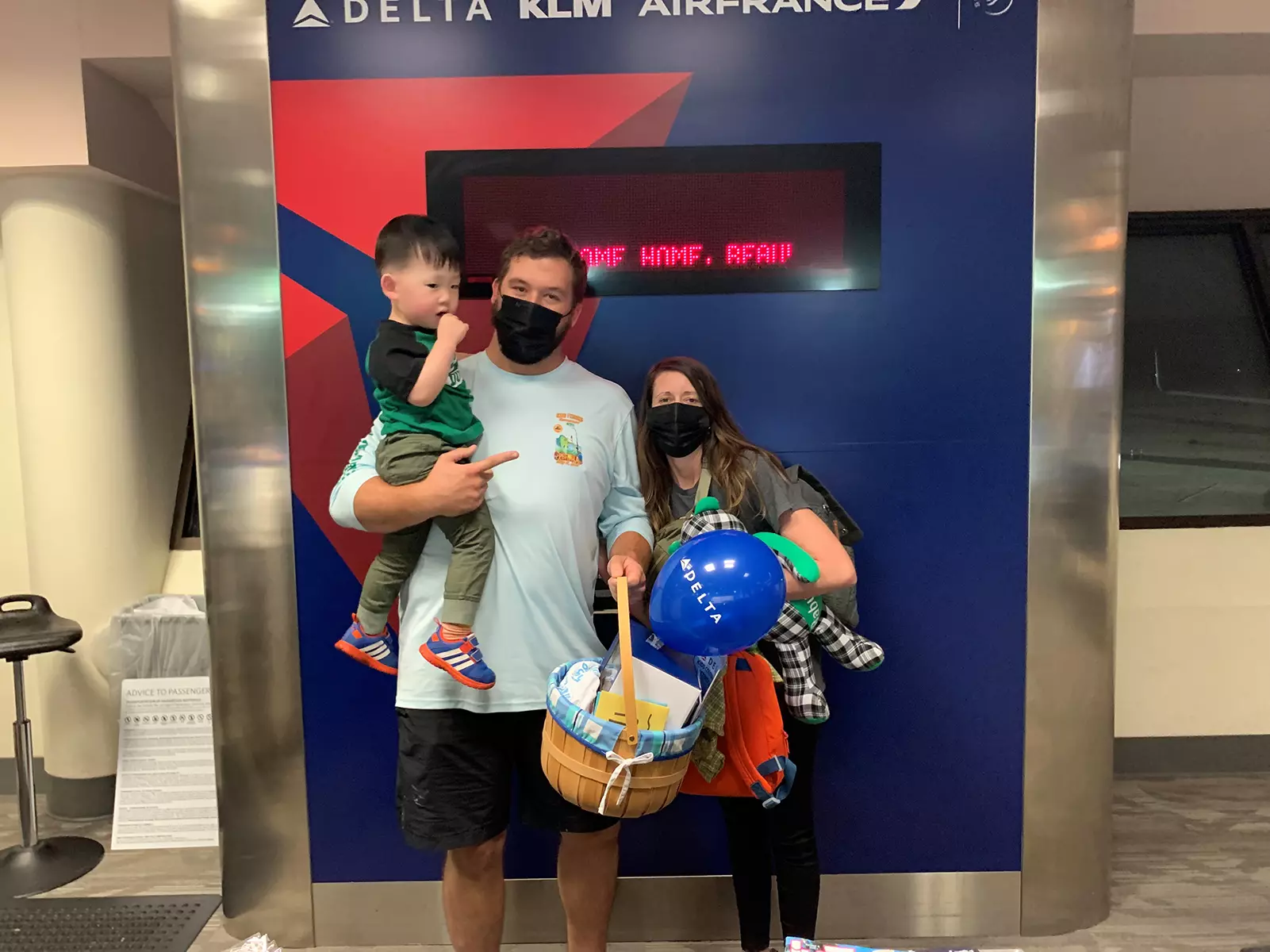 Unha familia está diante dun taboleiro de Delta Air Lines que le