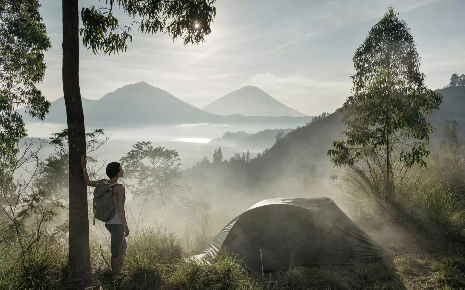 nézi a kilátást, miközben kempingezett a Kintamani gerincen, a Mount Agung vulkán előtt, napkeltekor Balin