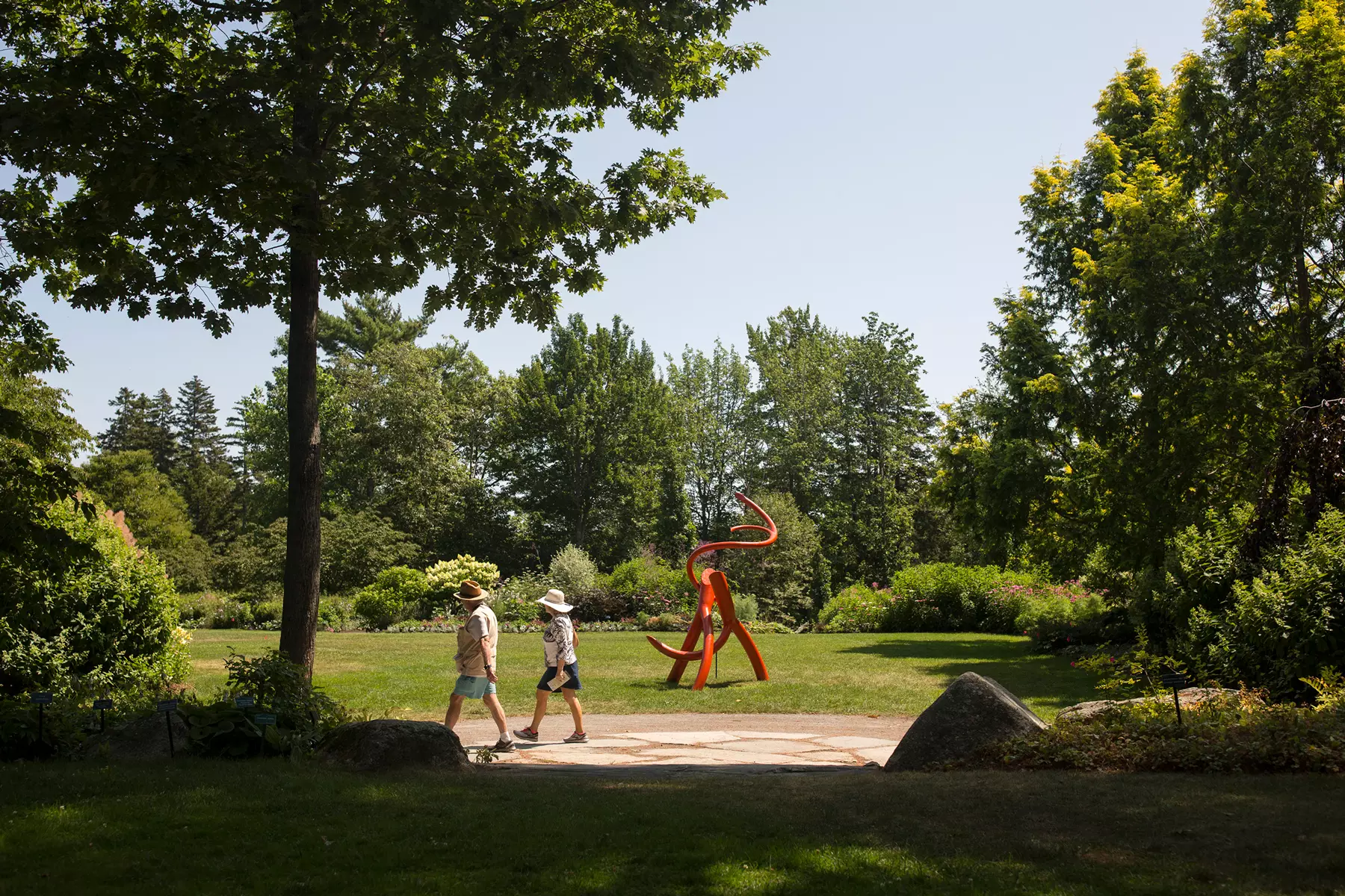 I visitatori dei Coastal Maine Botanical Gardens camminano vicino a una scultura dell'artista Steve Tobin venerdì 2 agosto 2019