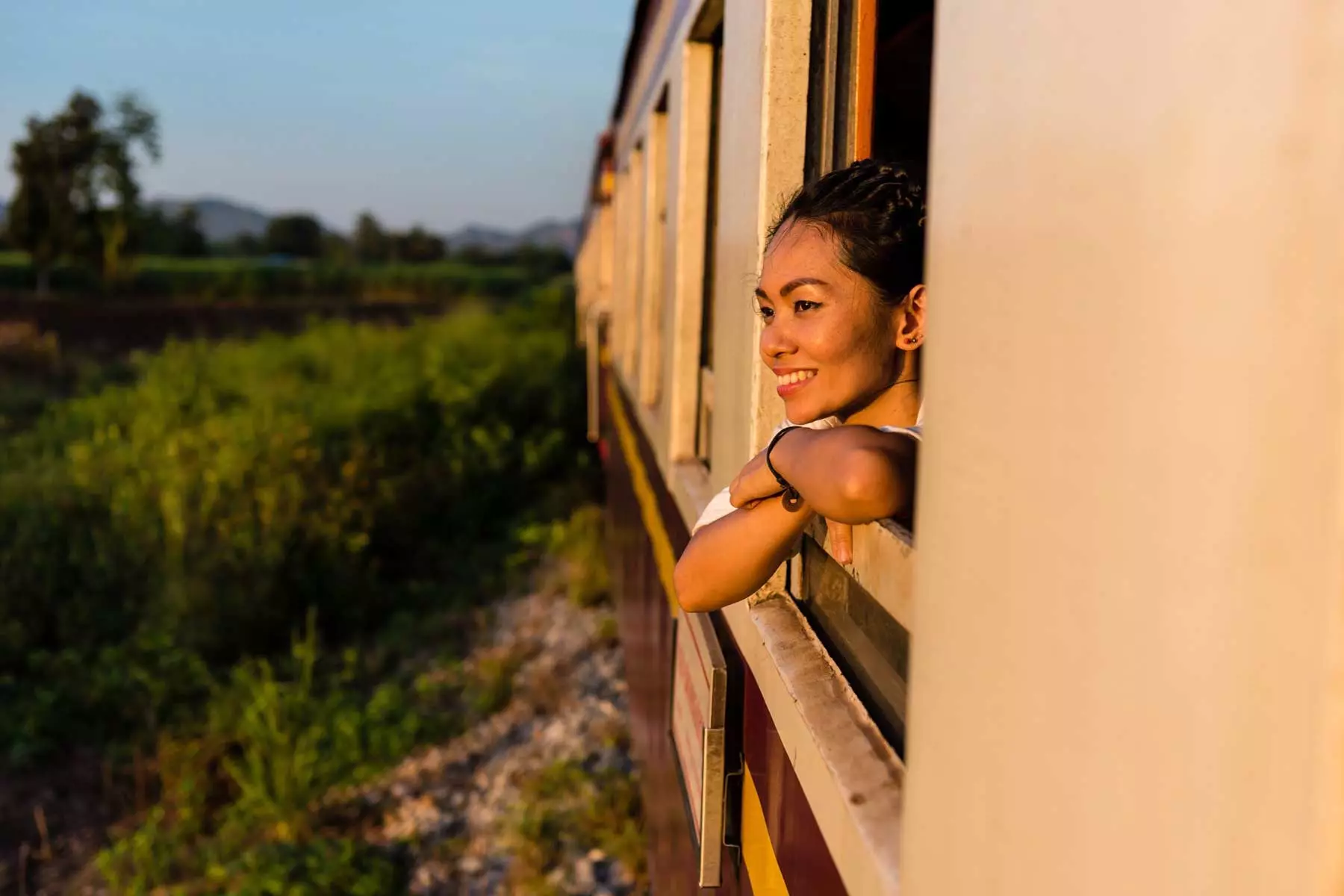 微笑的女人透過火車窗看