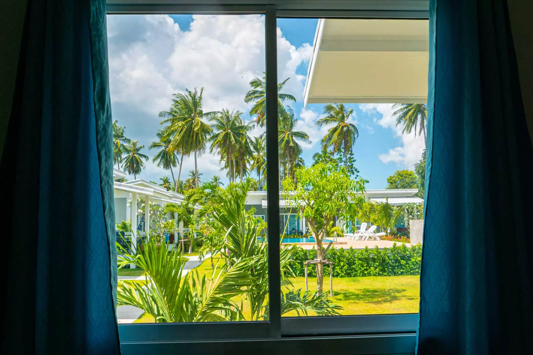 Vista des de la finestra de l'hotel, piscina i palmeres