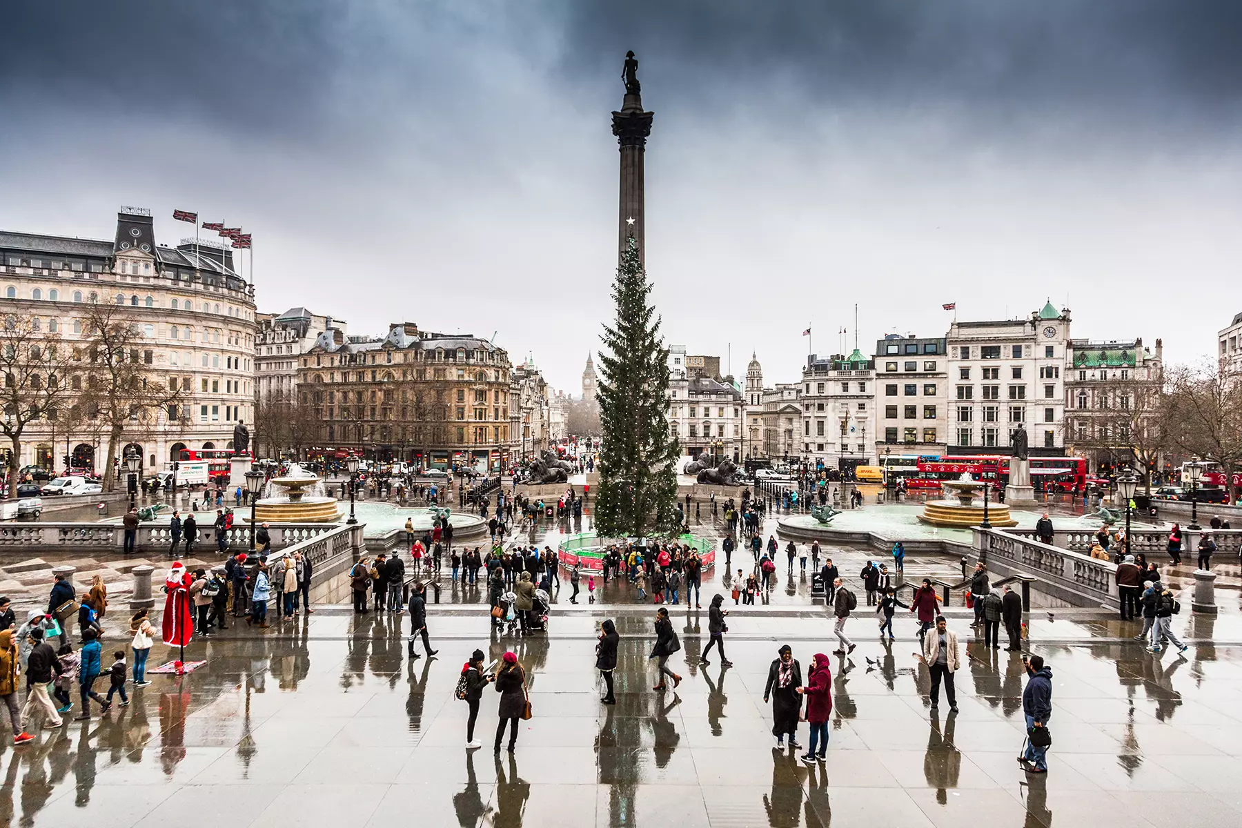 Turistoj apud la Kristnaska Arbo en Trafalgar Square, Londono, Britio