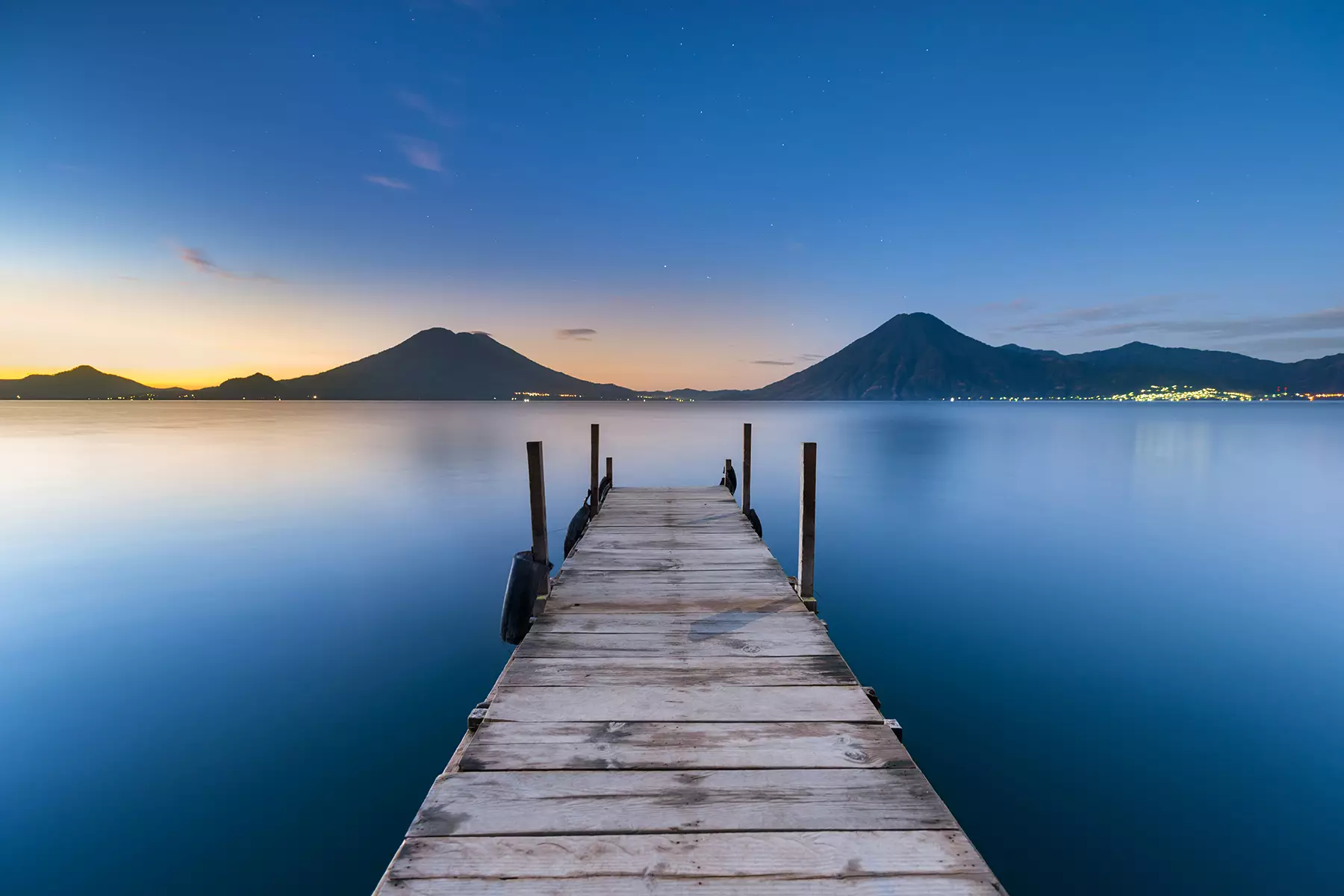 Pemandangan sing katon mudhun ing dermaga ing Lake Atitlán nalika srengenge munggah.