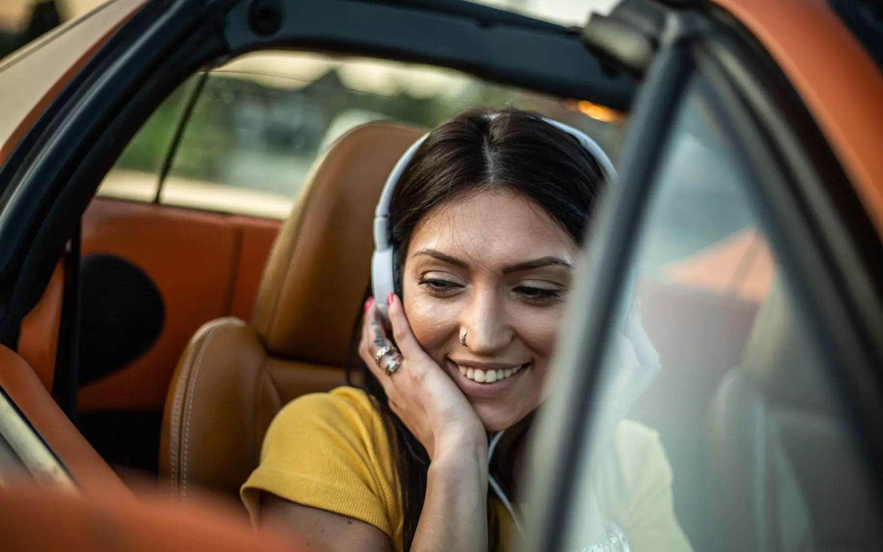 Կինը մեքենայում ականջակալներով երաժշտություն է լսում