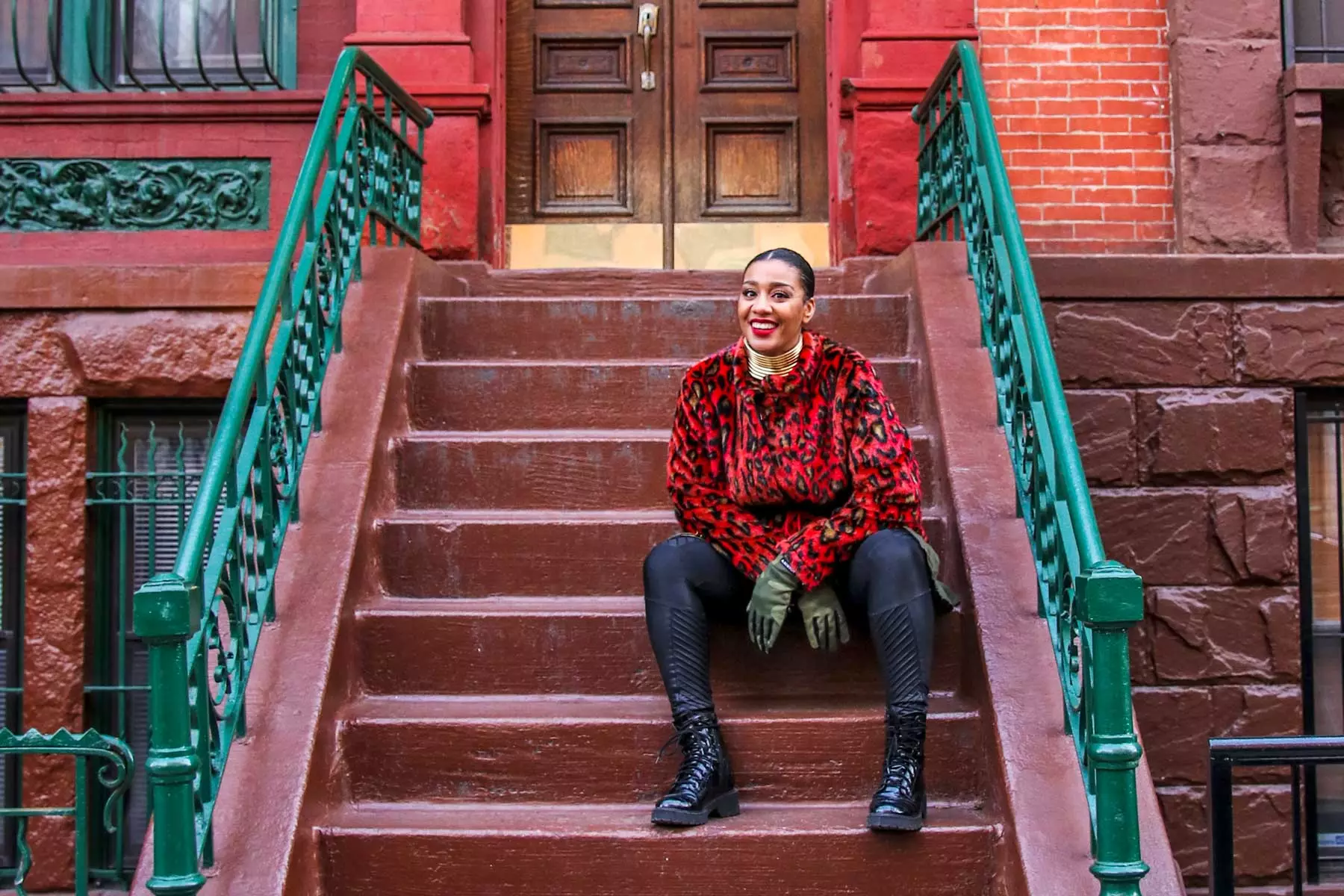 Evita Robinson duduk di tangga rumah bandar di Harlem, New York