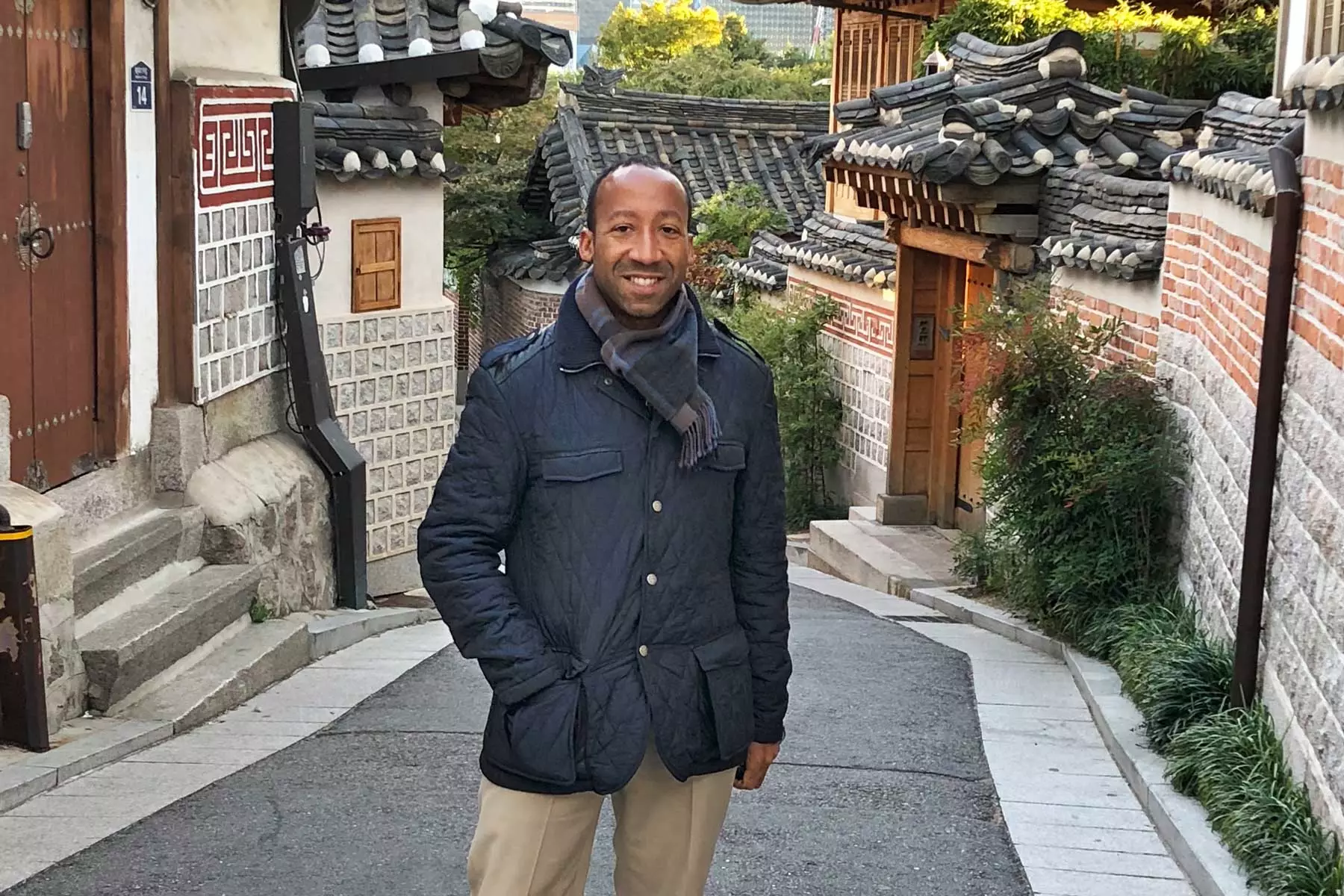 Il consulente di viaggio Kareem George posa per una foto in una stradina di Seoul, in Corea