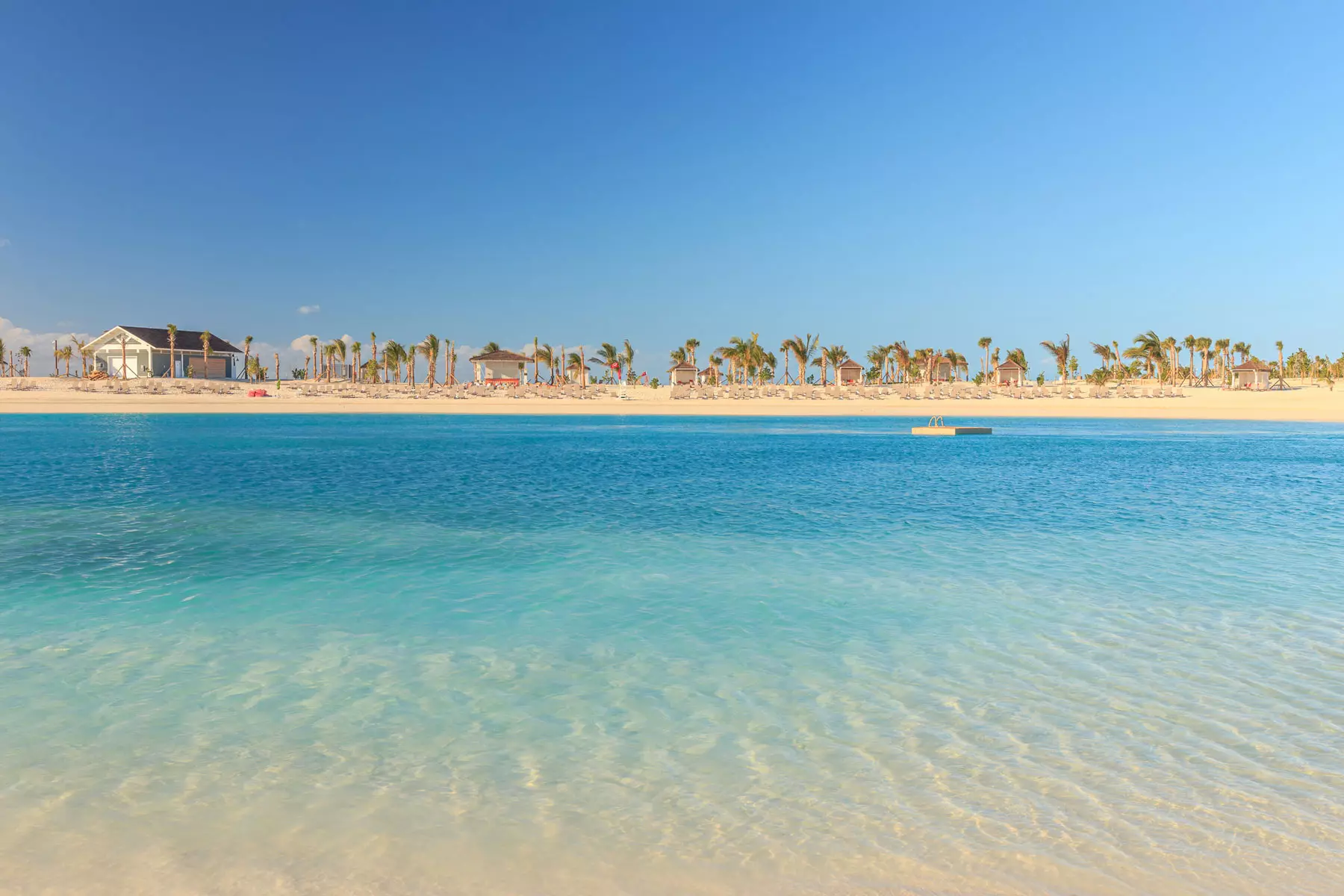 Utsikt over palmekantet strand fra klart blått vann i Nassau, Bahamas