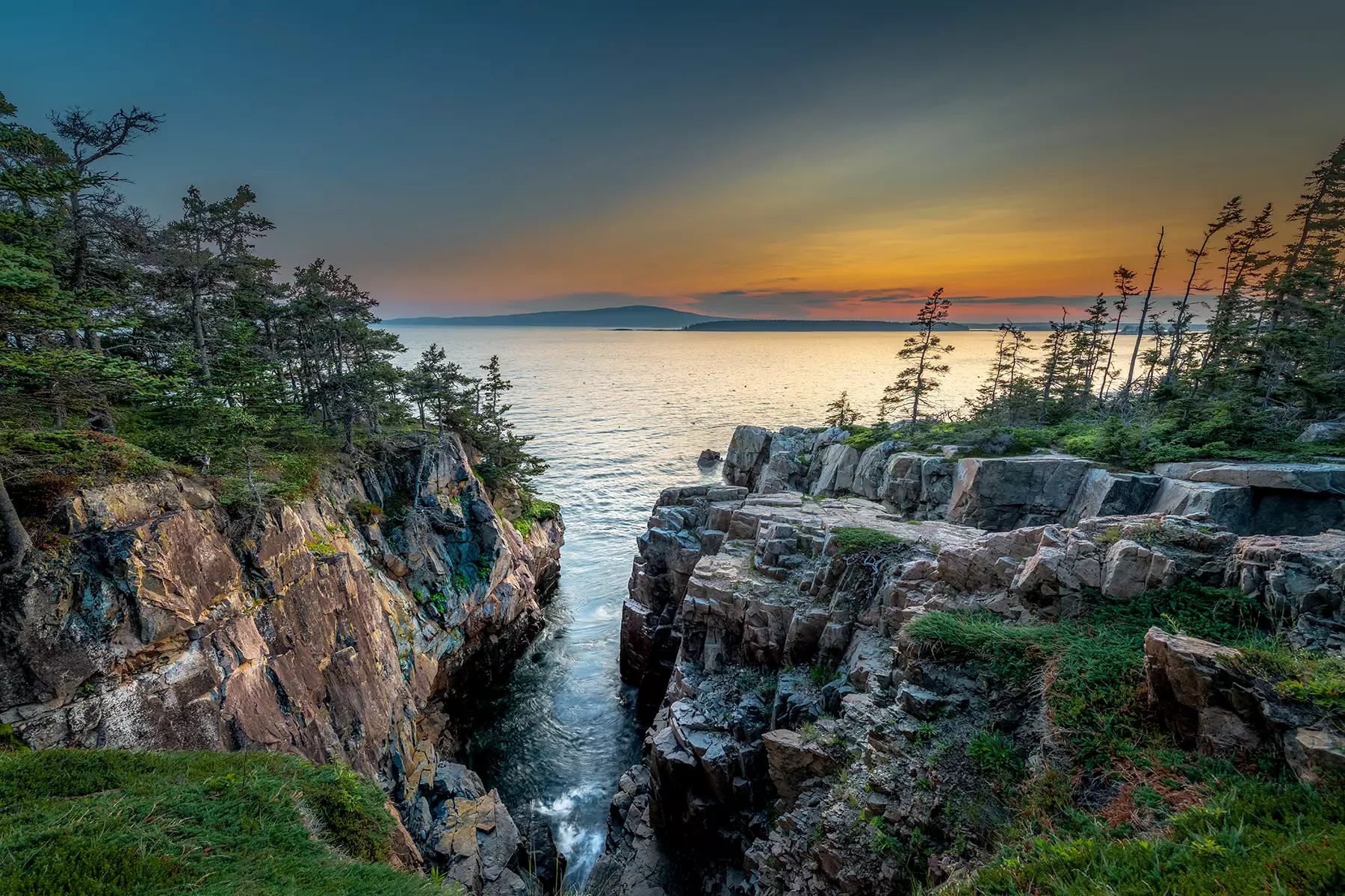 Acadia National Park और Cadillac Mountain की ओर देखते हुए Ravens Nest पर सूर्यास्त के नज़ारे। रेवेन्स नेस्ट शूडिक प्रायद्वीप पर स्थित है।