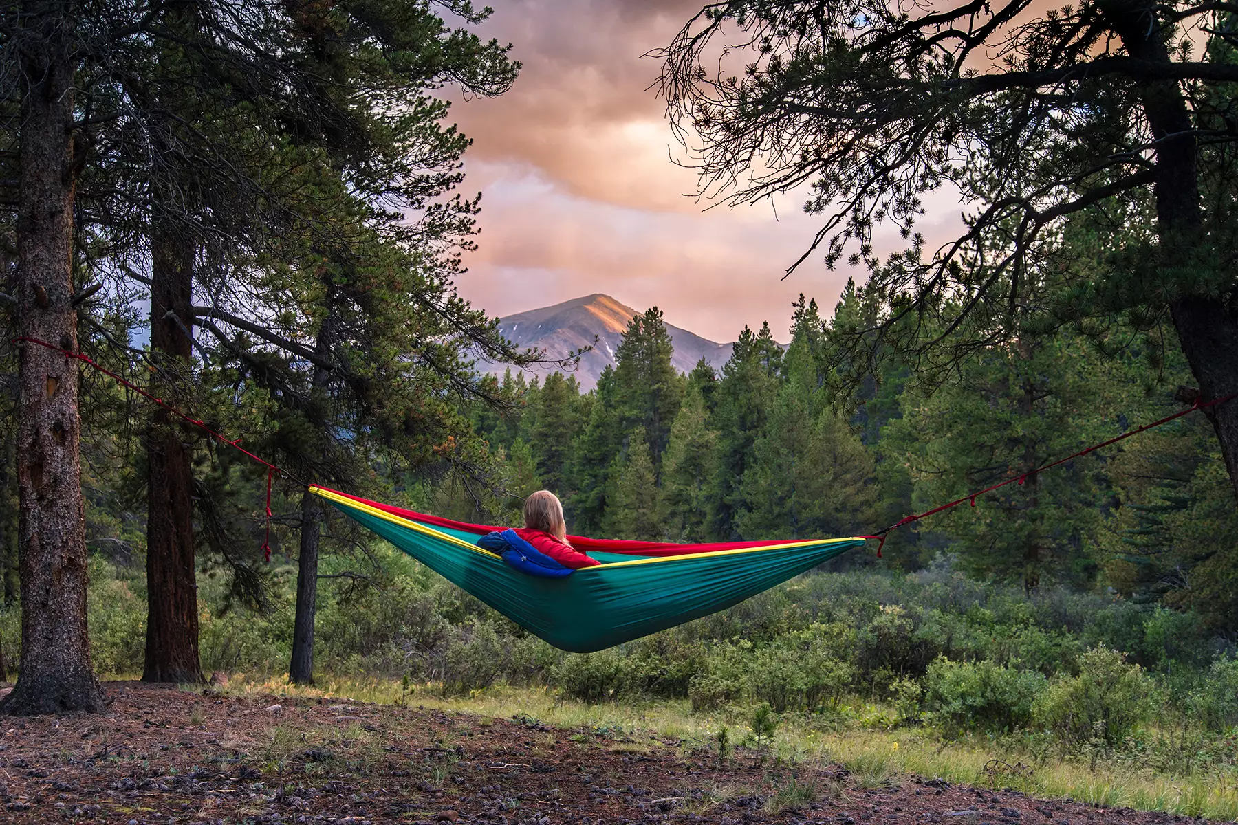 Mara tistrieħ f'hammock fil-foresta f'Leadville, Colorado,