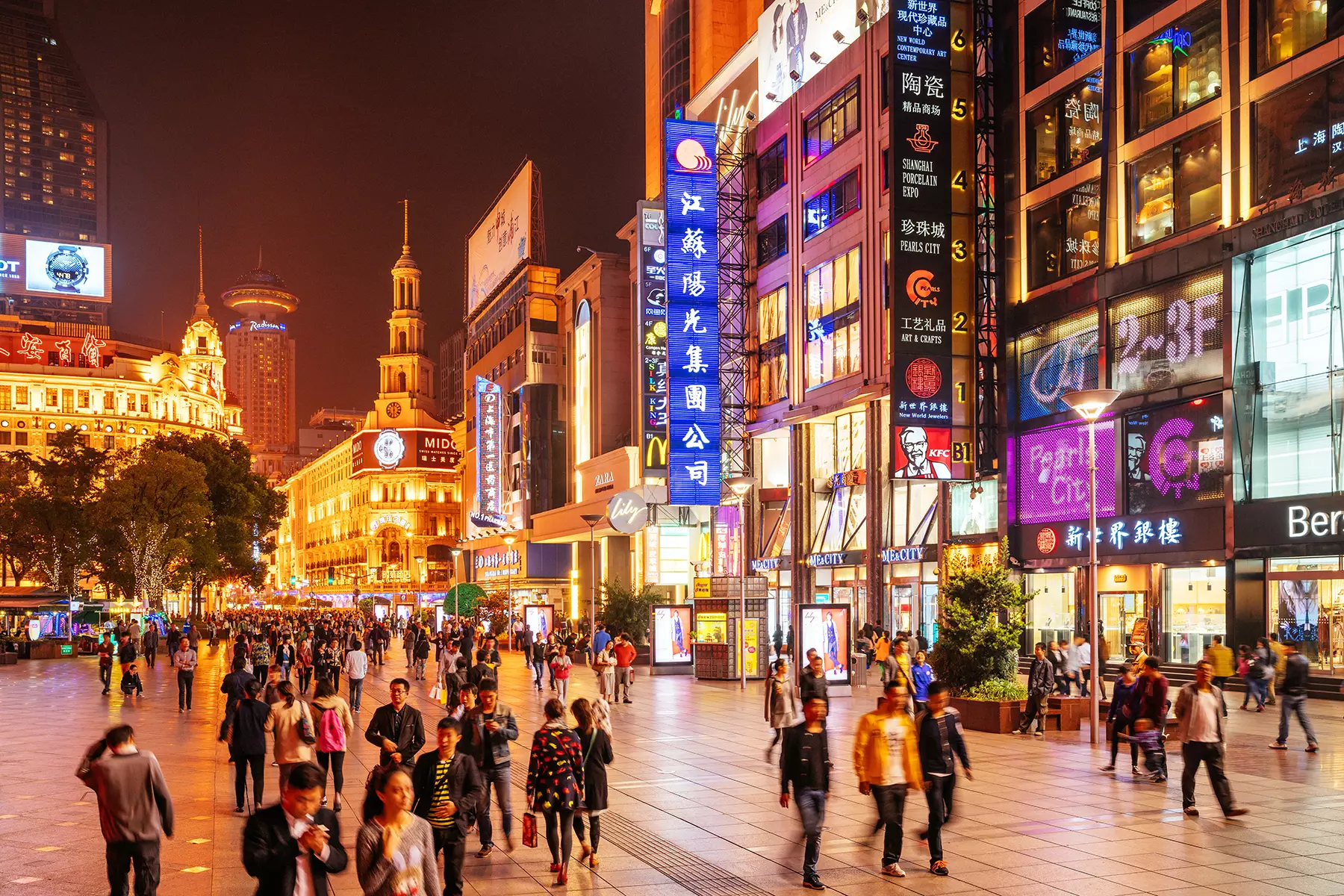 Tłumy chodzą pod neonami na Nanjing Road. Ulica jest główną dzielnicą handlową miasta i jedną z najbardziej ruchliwych dzielnic handlowych na świecie.