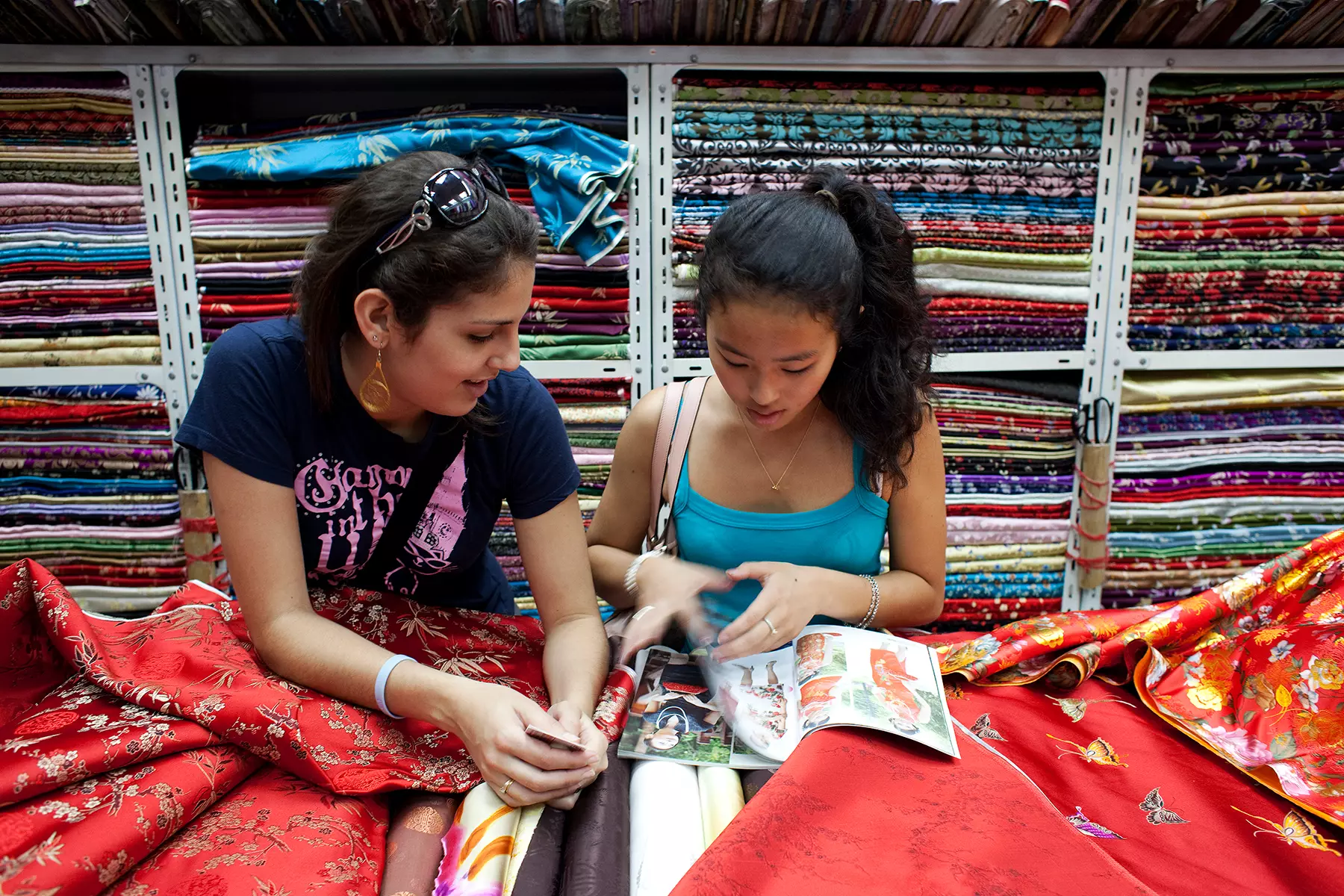 Turis tuku gaun ing Pasar Kain Bund Selatan, sing misuwur kanthi kain lan setelan potong, ing Shanghai, China.