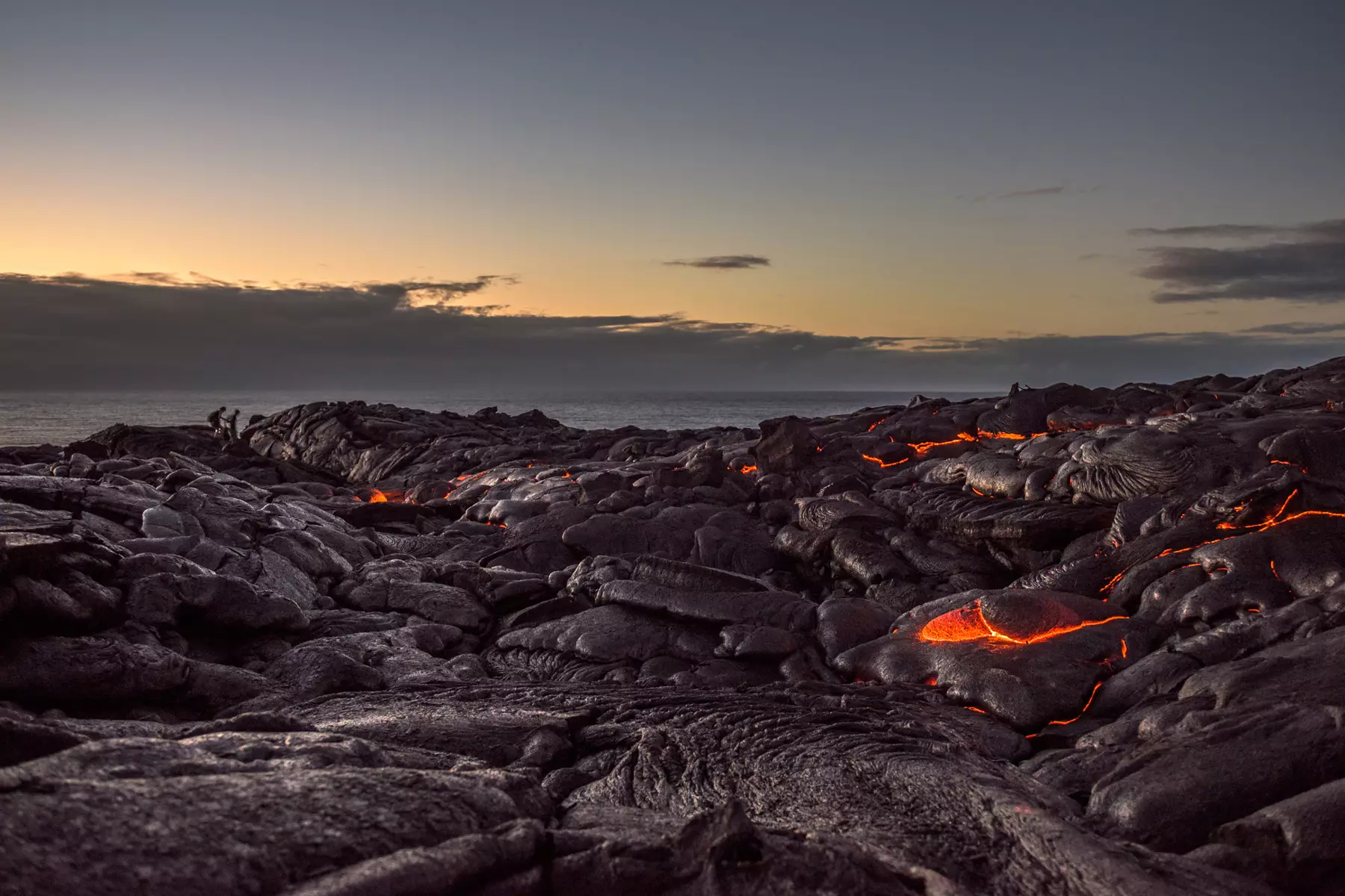 Berjalan di atas padang lava di pantai Pasifik berhampiran Kalapana di Pulau Besar Hawaii pada waktu subuh.