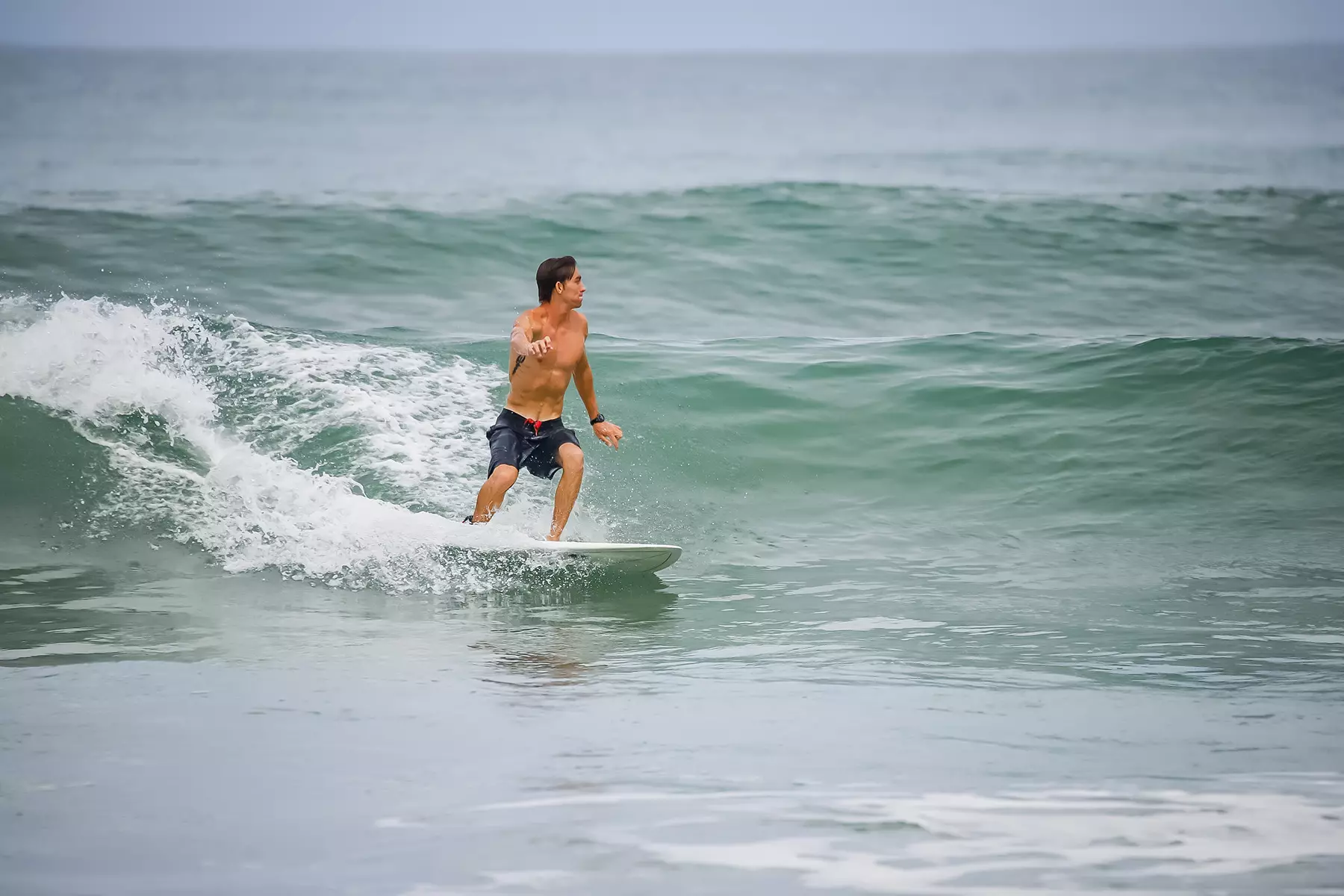 Um homem surfando com a Iguana Surf Vacations