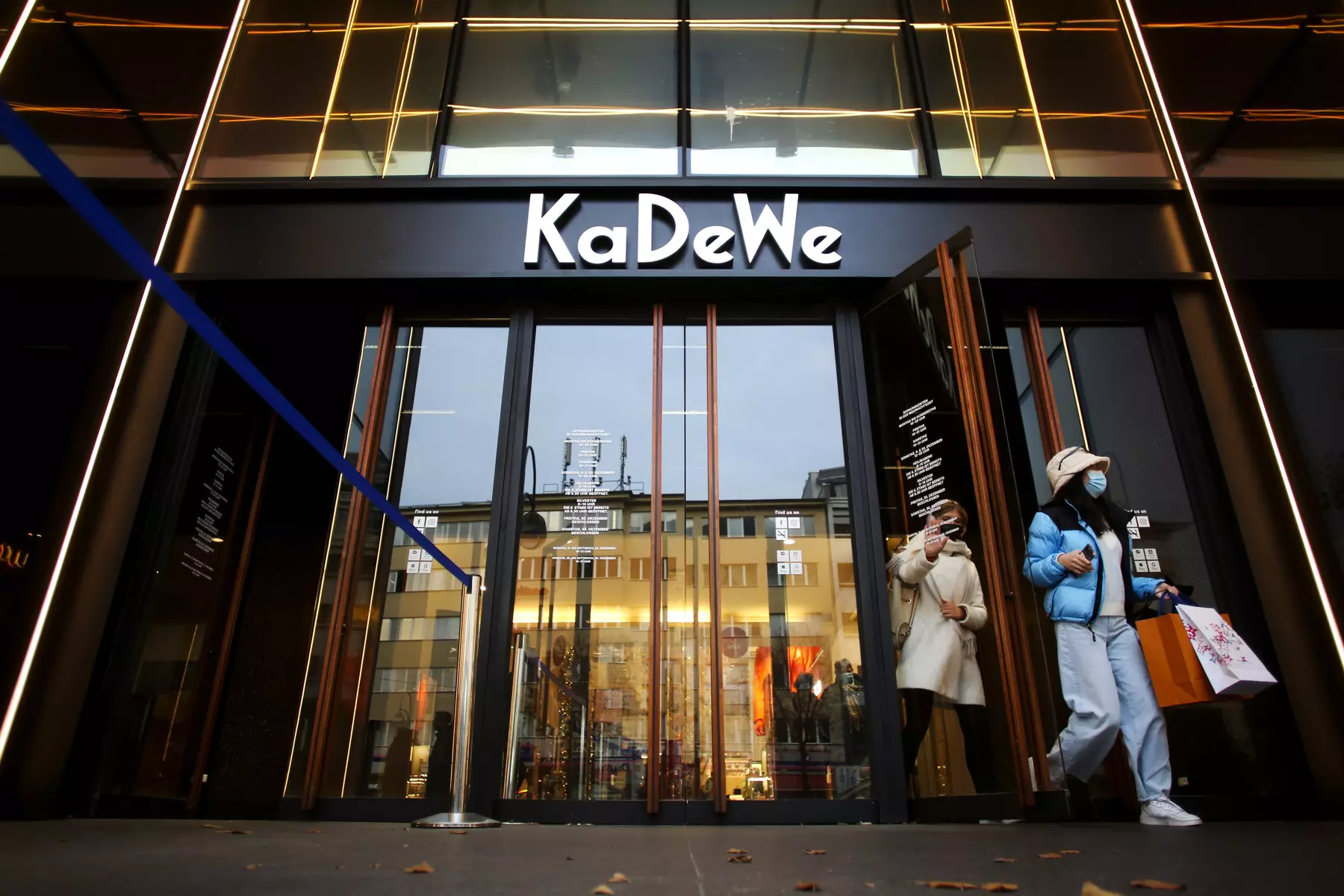 Pelanggan mengenakan masker pelindung saat keluar dari department store mewah KaDeWe, yang dioperasikan oleh Signa Prime Selection AG, di Berlin, Jerman