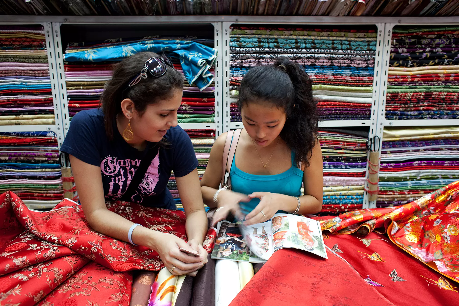 Ferðamenn versla kjóla á South Bund Fabric Market, frægum fyrir efni og klippingu, í Shanghai í Kína.