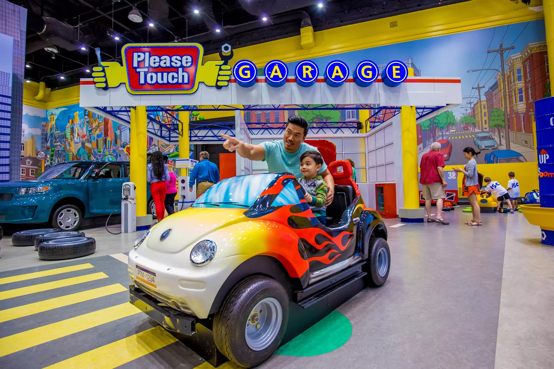 Pai e filho em carro de brinquedo no Please Touch Museum