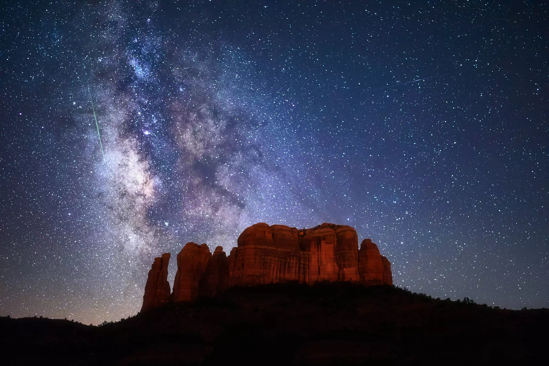 Vệt sao băng xuyên qua Dải Ngân hà phía trên Tảng đá Nhà thờ ở Sedona, Arizona.