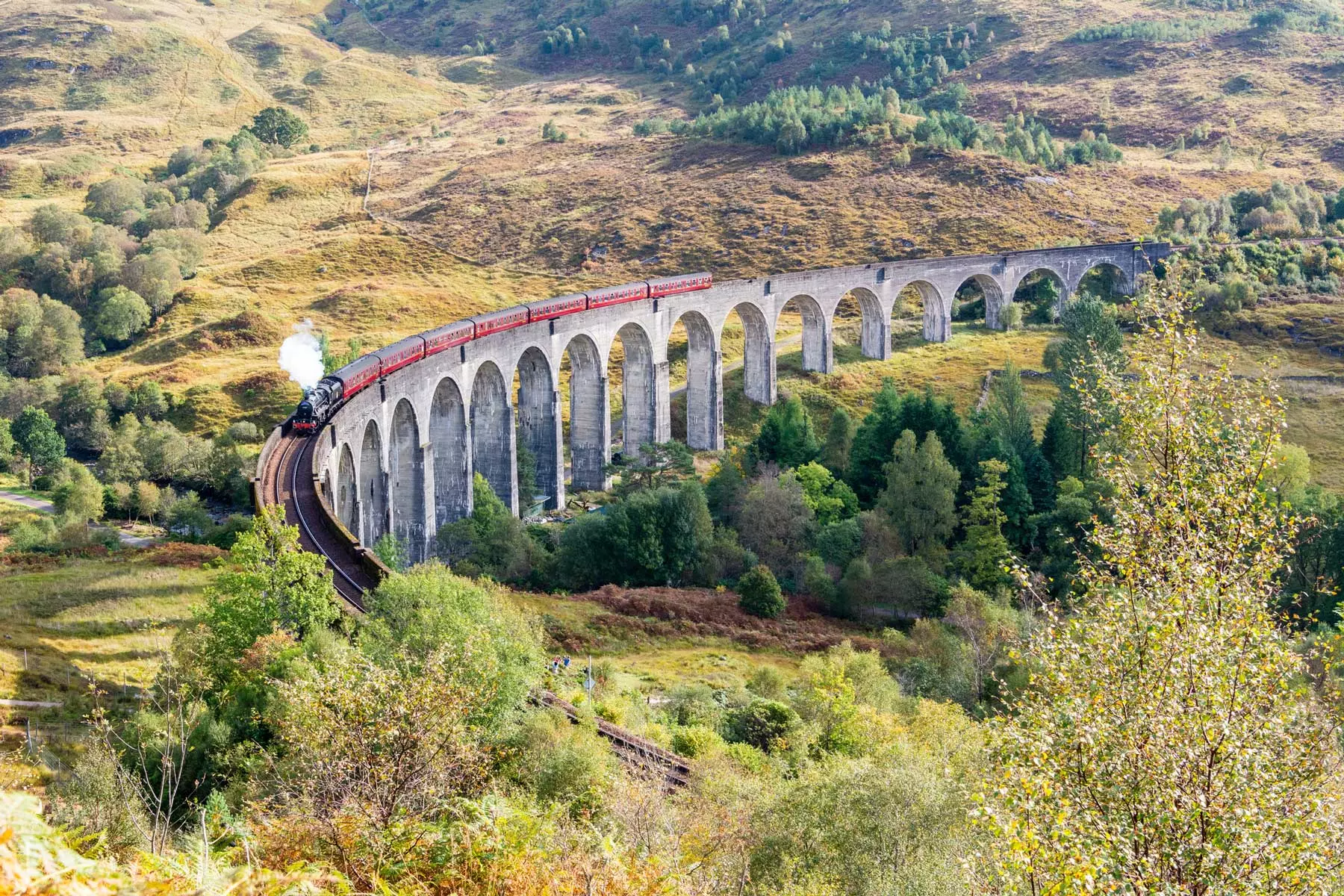 Železničný viadukt Glenfinnan v Škótsku s križovatkou parného vlaku. Viadukt bol postavený v roku 1901.