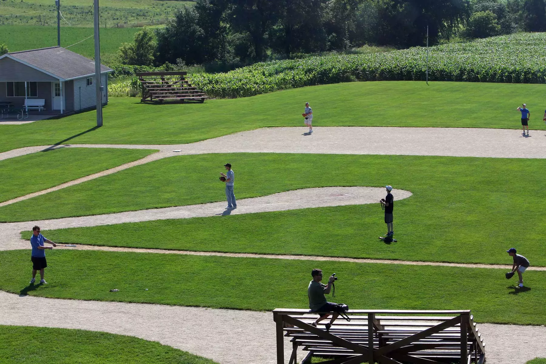 Turiștii țin mingea la locul de filmare Field of Dreams din Dyersville, Iowa