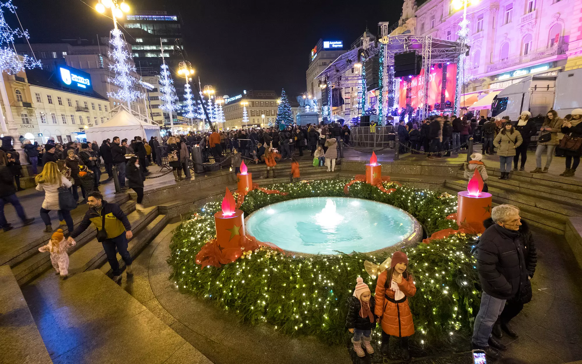 クロアチア、ザグレブ-12月22日：地元の人々は、2015年12月22日、クロアチアのザグレブにあるメイン広場のクリスマスに飾られた噴水で写真と自撮り写真を撮ります。ザグレブは先週、今年のヨーロッパのクリスマスマーケットに選ばれ、クリスマスのトップの1つに選ばれました。