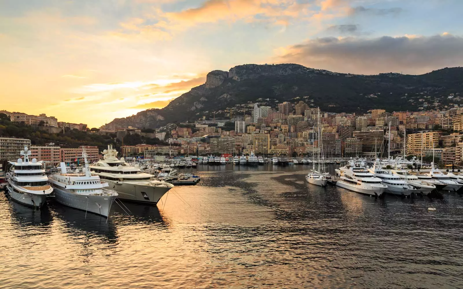 Aanskoulike sonsondergang oor super seiljagte, glansryke hawe van Monaco