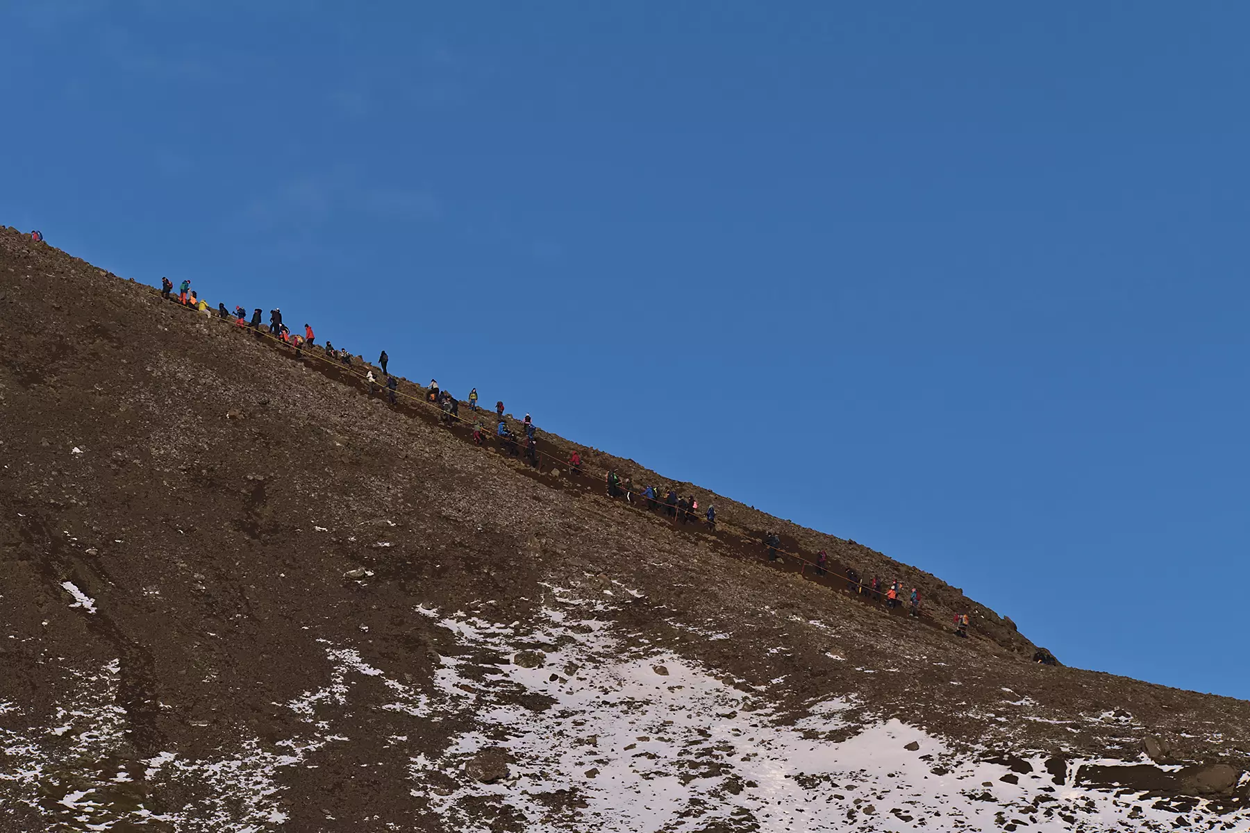 Mutanen da ke hawa dutsen dutse akan hanyar tafiya zuwa wani dutsen mai aman wuta da ya tashi a kusa da dutsen Fagradalsfjall a kwarin Geldingadalir a kudu maso yammacin Iceland a tsibirin Reykjanes.