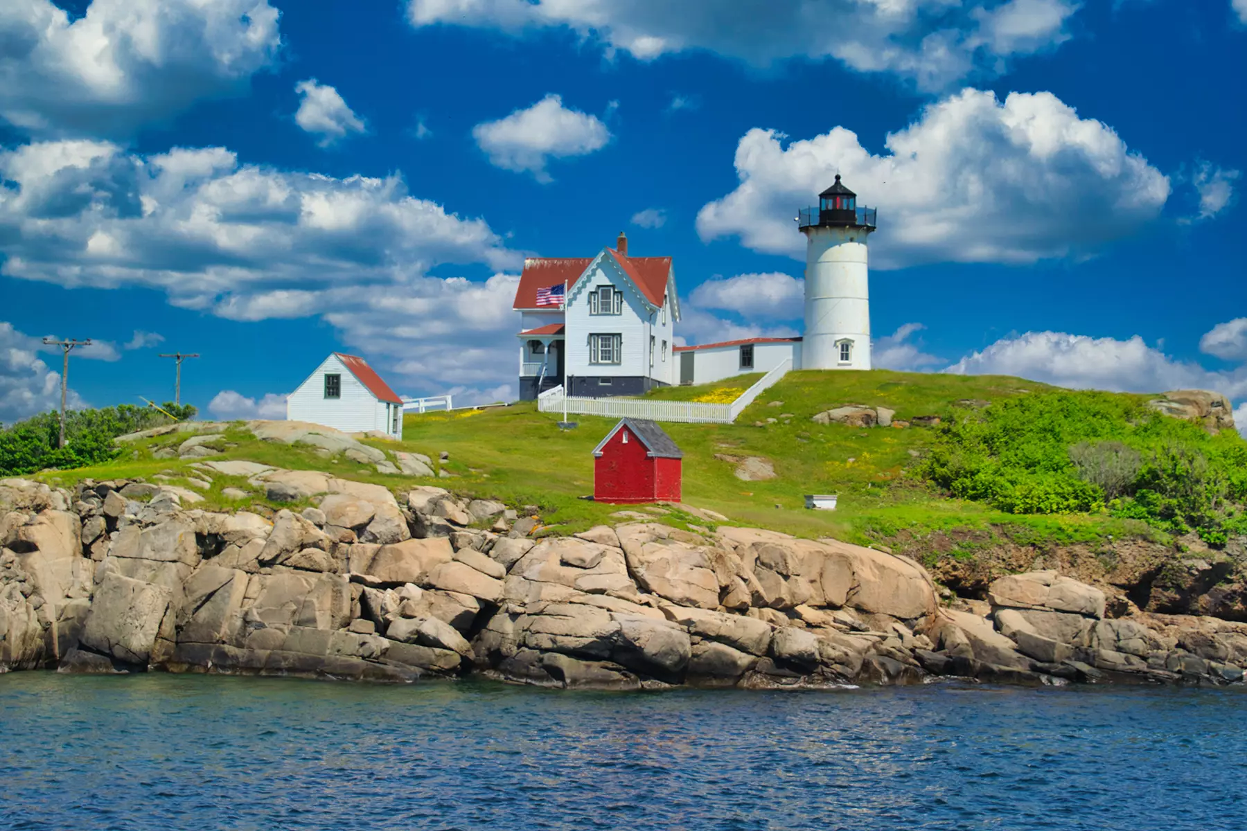 Cape Neddick (Nubble) Haske yana zaune a kan wani ƙaramin tsibirin dutse da aka sani da Nubble kusa da bakin tekun York, Maine.