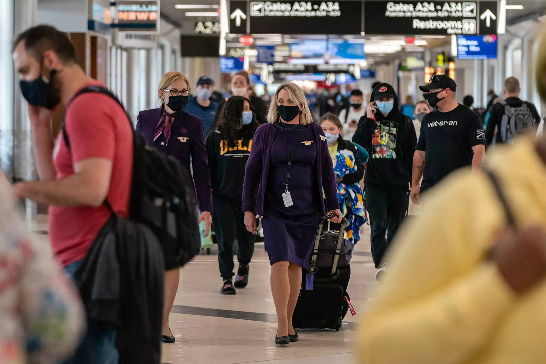 Stewardessen met beschermende maskers lopen door Hartsfield-Jackson Atlanta International Airport in Atlanta