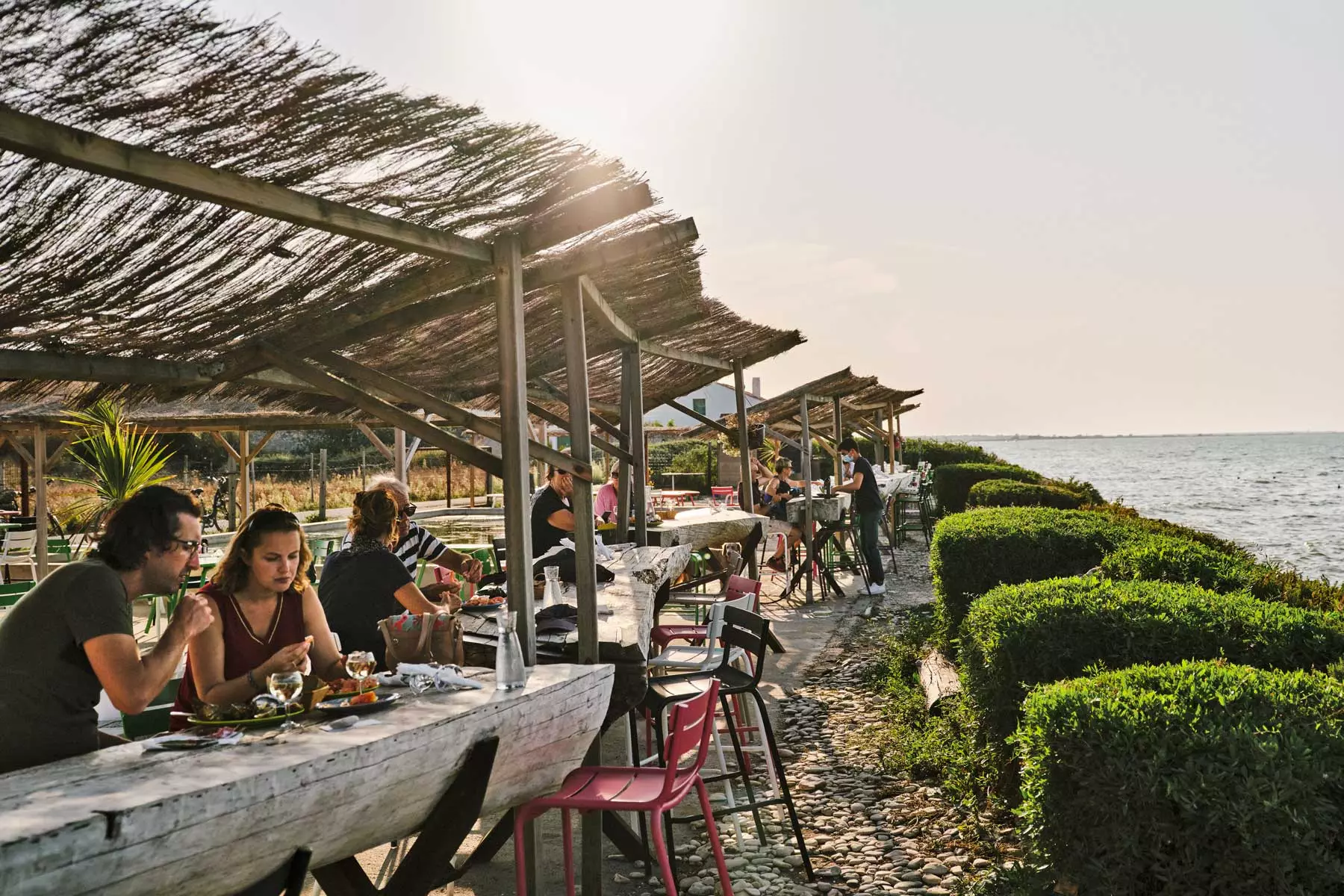 Les clients de manger des huîtres sur la terrasse au bord de l'eau du restaurant Re Ostrea en Ile de Ré, France