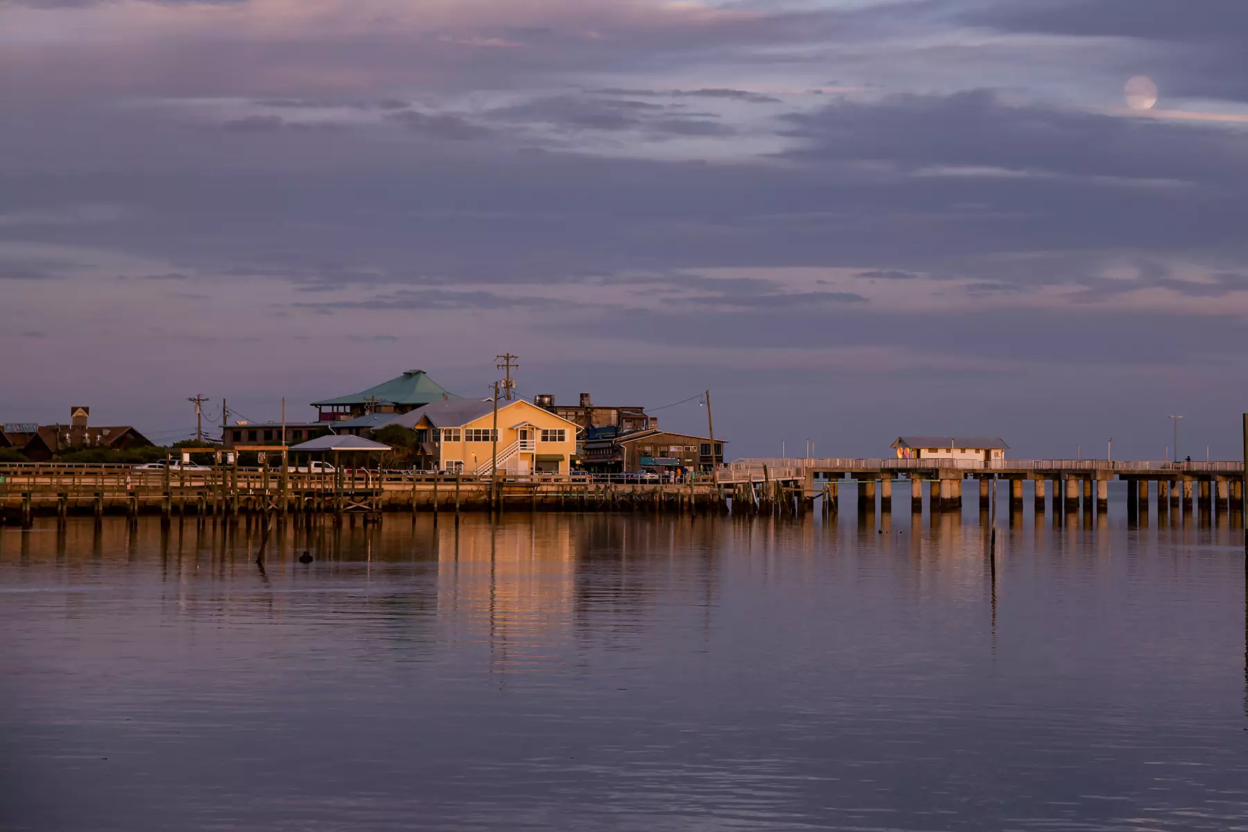 Ikirere nimugoroba hamwe ukwezi kurenga hejuru ya Dock Street muri Cedar Key, Floride