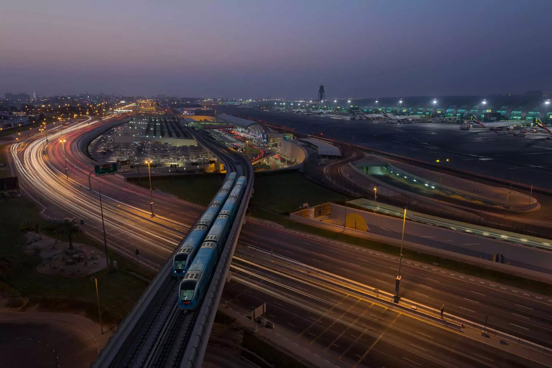 Aeropuerto de Dubái, trenes y autopistas del metro de Dubái por la noche