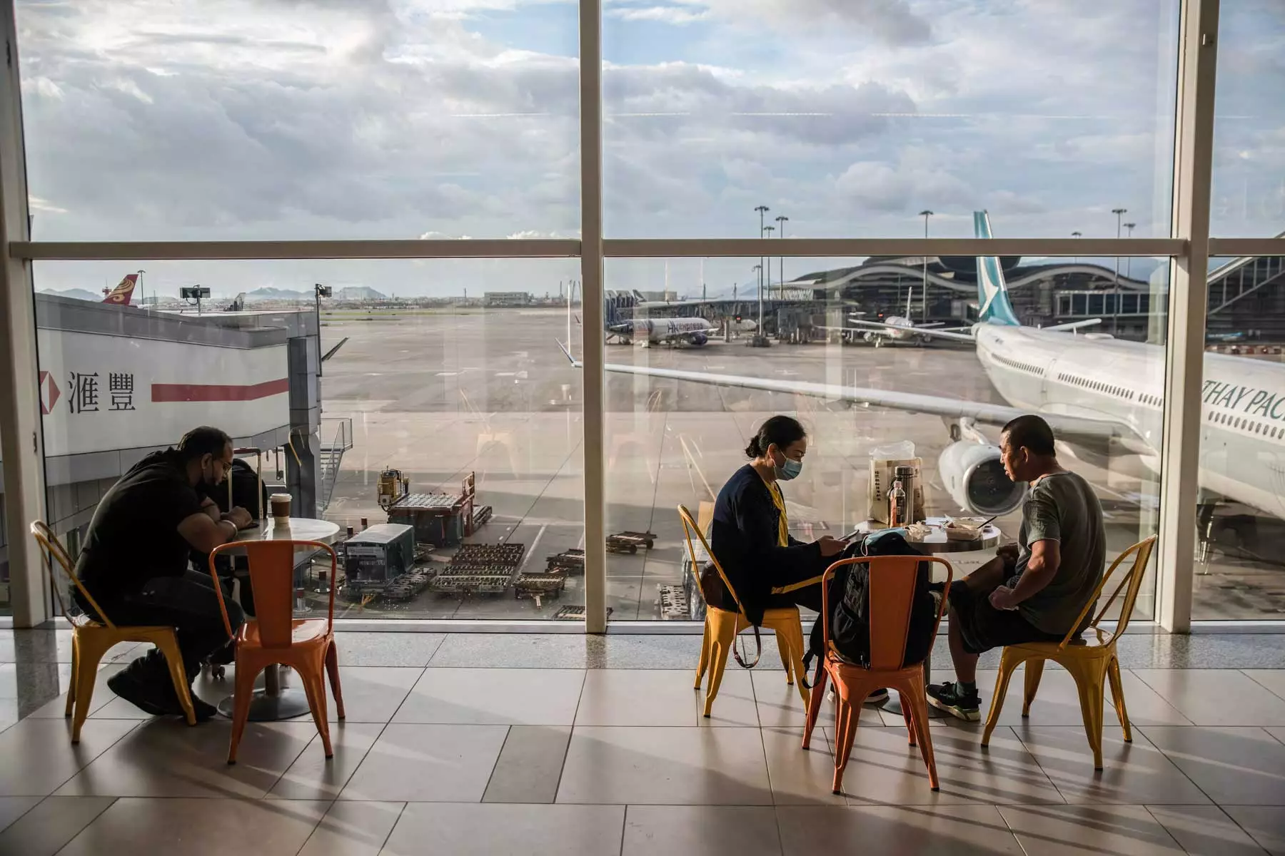 Los pasajeros disfrutan de sus comidas en la sala de salidas del Aeropuerto Internacional de Hong Kong