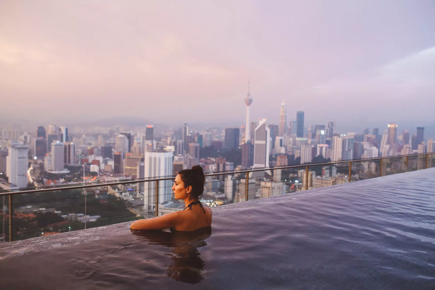 Usa ka babaye sa pool nga naglangoy sa ibabaw sa usa ka building sa Kuala Lumpur, Malaysia.