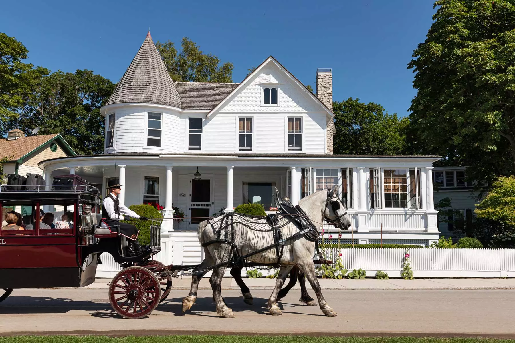 Szenen vun der Mackinac Island: e Päerdskutsch passéiert virun engem Wäissen Haus