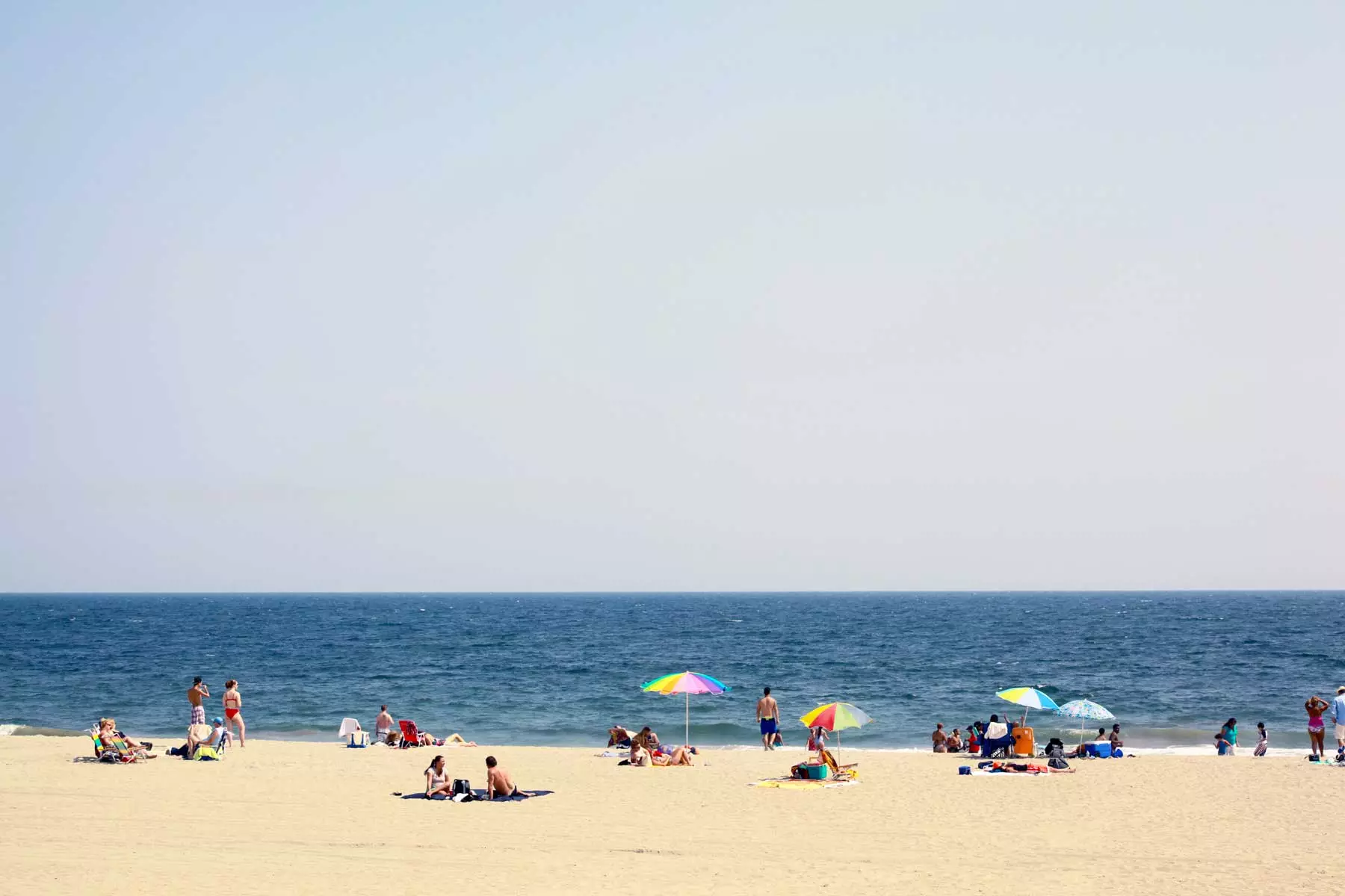Lidé si užívají Rockaway Beach v Queensu v New Yorku