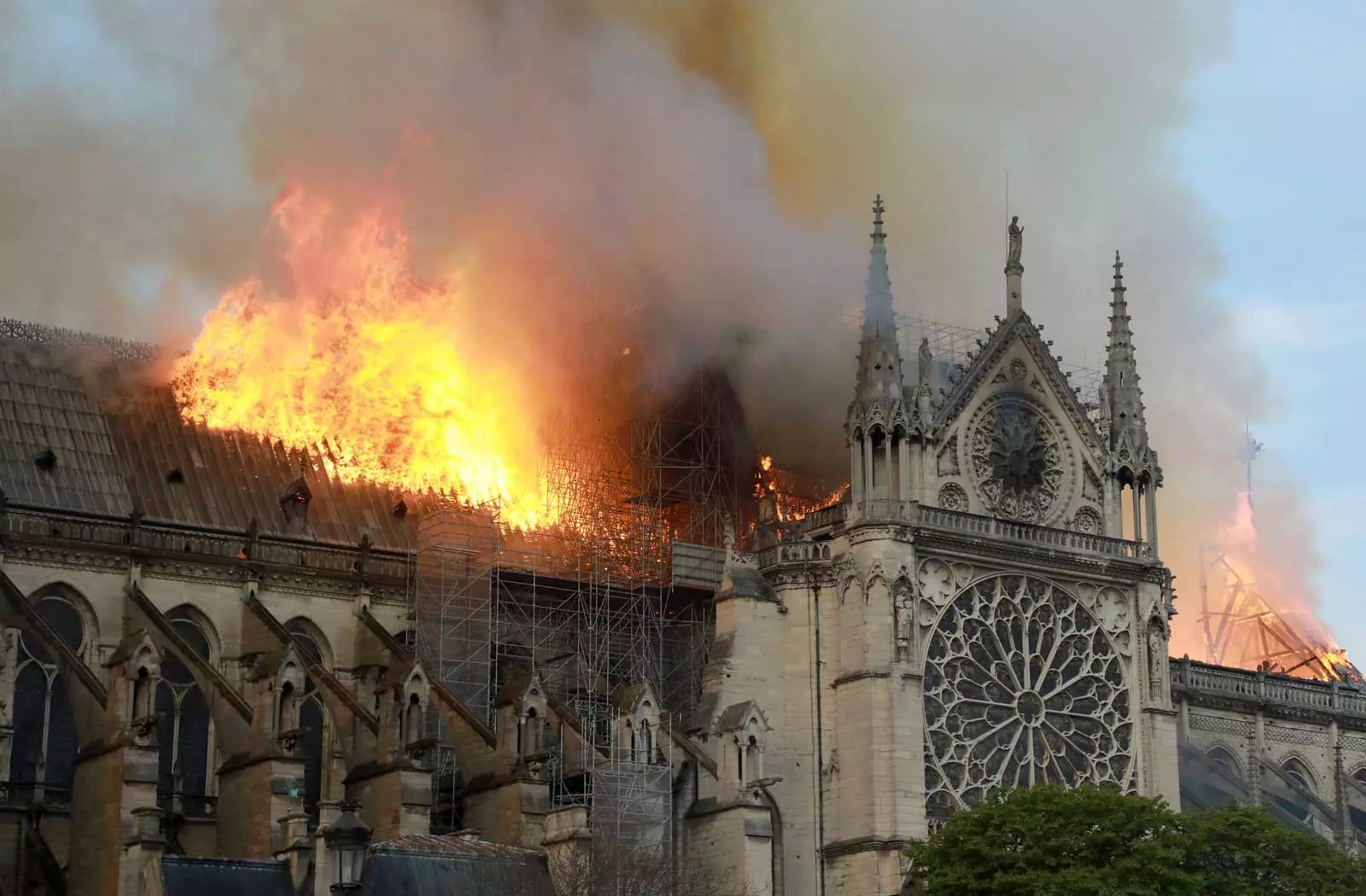 Feictear lasracha agus deatach ag sruthán ón díon ag Ardeaglais Notre-Dame 15 Aibreán, 2019 i bPáras na Fraince.