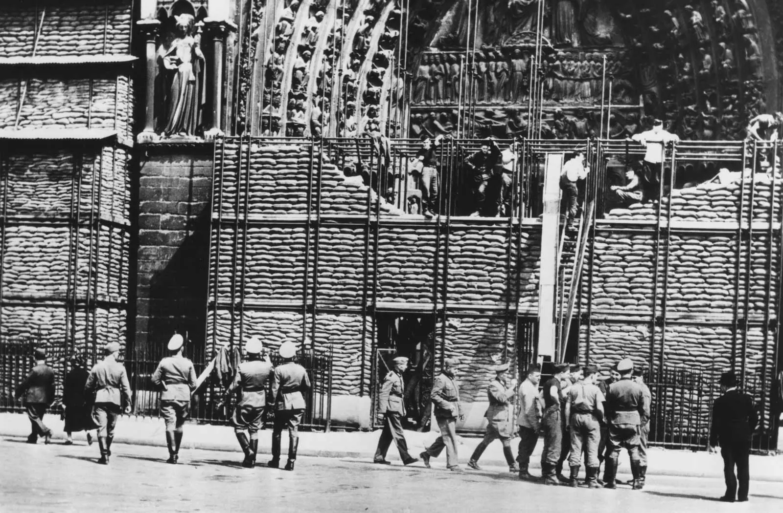 Pastrimi i mbrojtjes së qeseve me rërë nga fasada e Notre Dame, Parisi i pushtuar nga Gjermania, 1940.