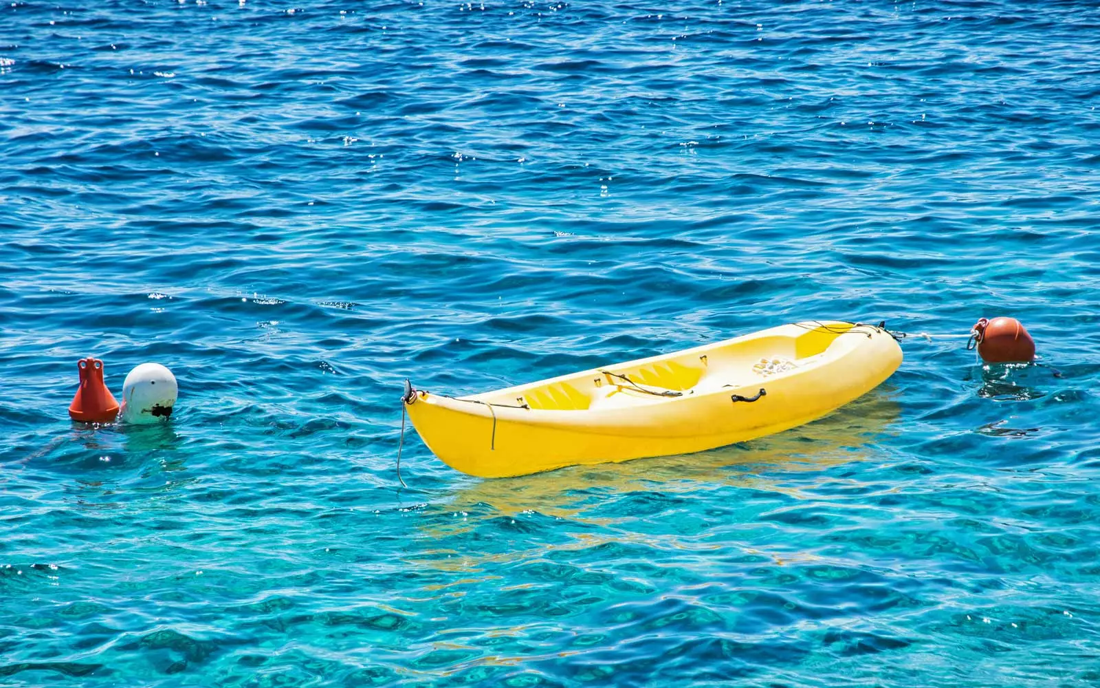 Kayak amarillo anclado en Maslinica, isla de Solta, Croacia