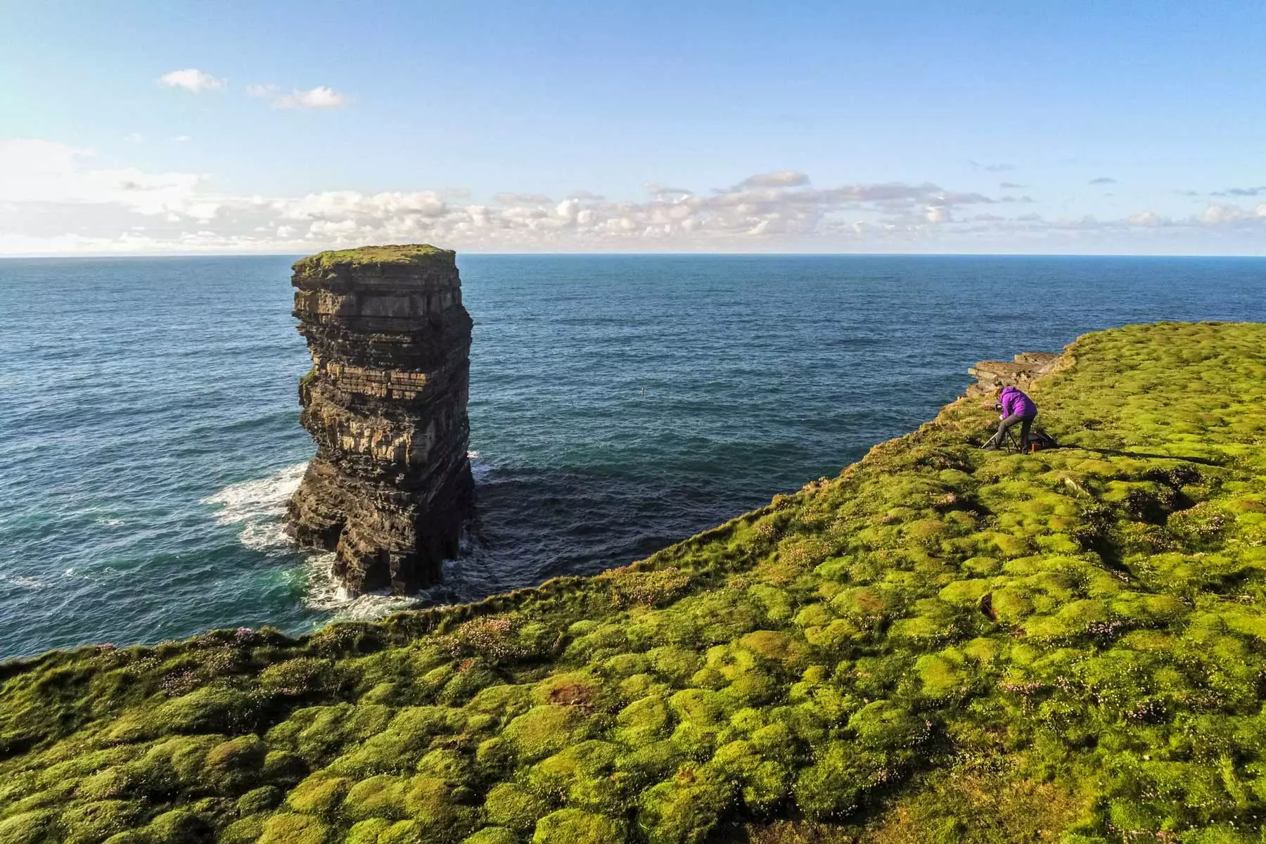 Ein Fotograf richtete eine Kamera ein, um ein Foto von Dun Briste Sea Stack in der Grafschaft Mayo, Irland, zu machen