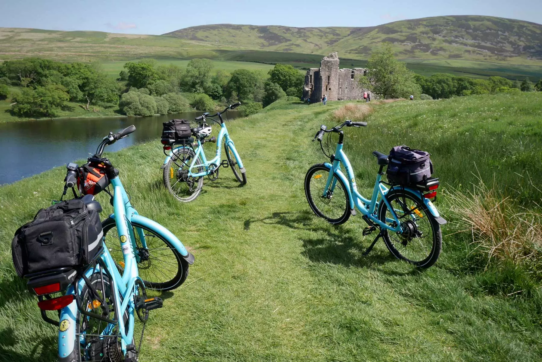 Trije fytsen op in gerspaad dat liedt nei it Morton Castle yn Skotlân